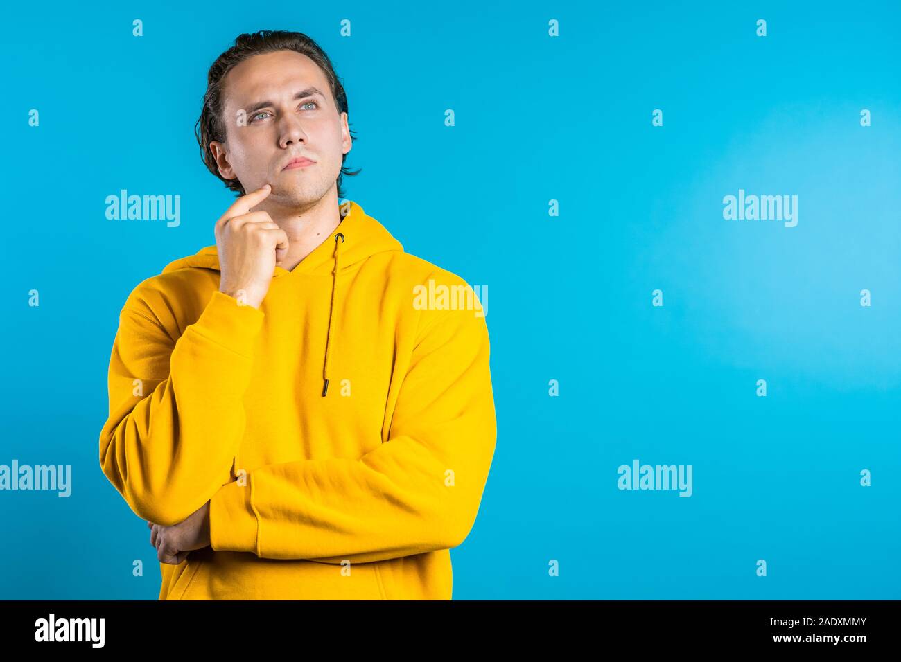 Copy space.Thinking man looking up and around on blue background ...