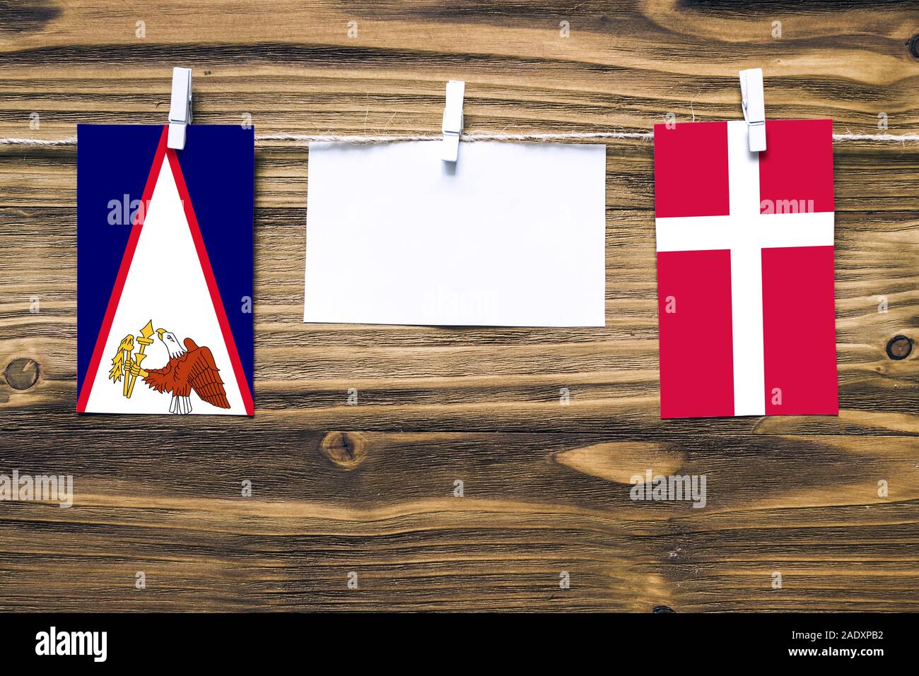 Hanging flags of American Samoa and Denmark attached to rope with ...