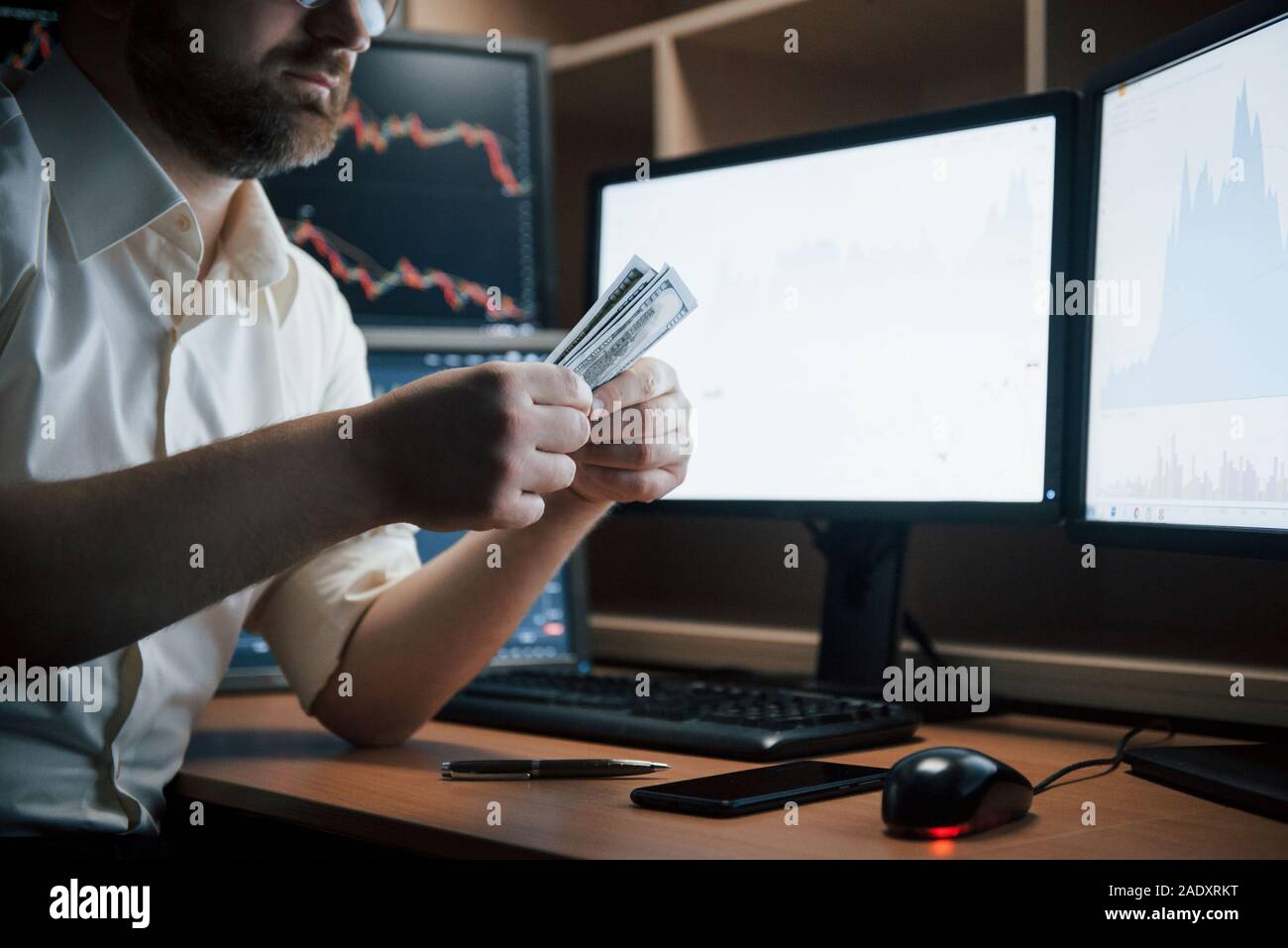 Rich entrepreneur calculates his cash. Bearded man in white shirt and ...