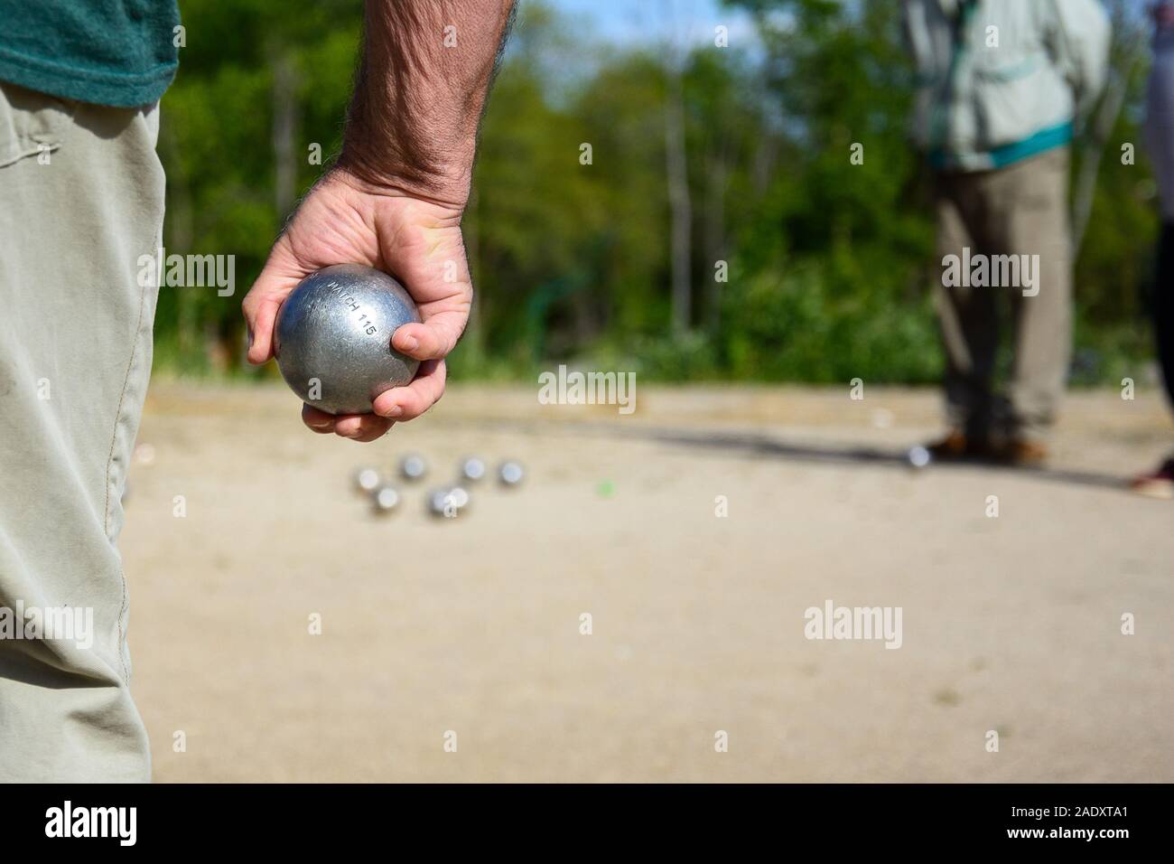 senior people prepared to throw the boules ball in a park in outdoor ...