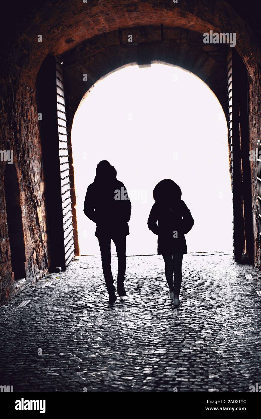 Young man and woman walking through a tunnel passage Stock Photo - Alamy