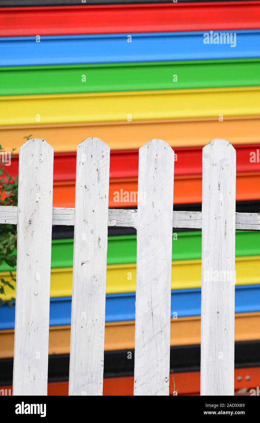 White picket fence against colorful wall Stock Photo - Alamy