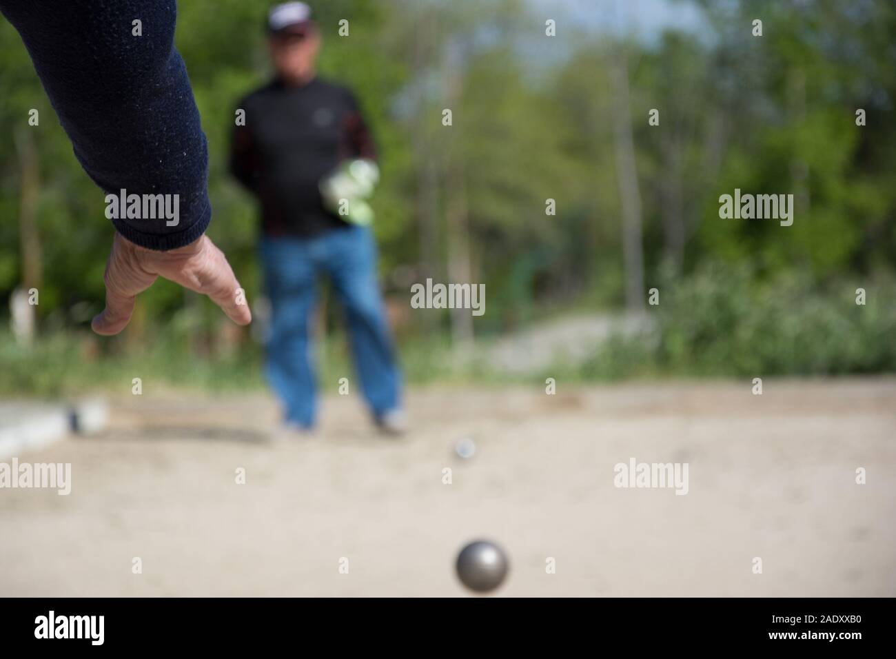 senior people prepared to throw the boules ball in a park in outdoor ...