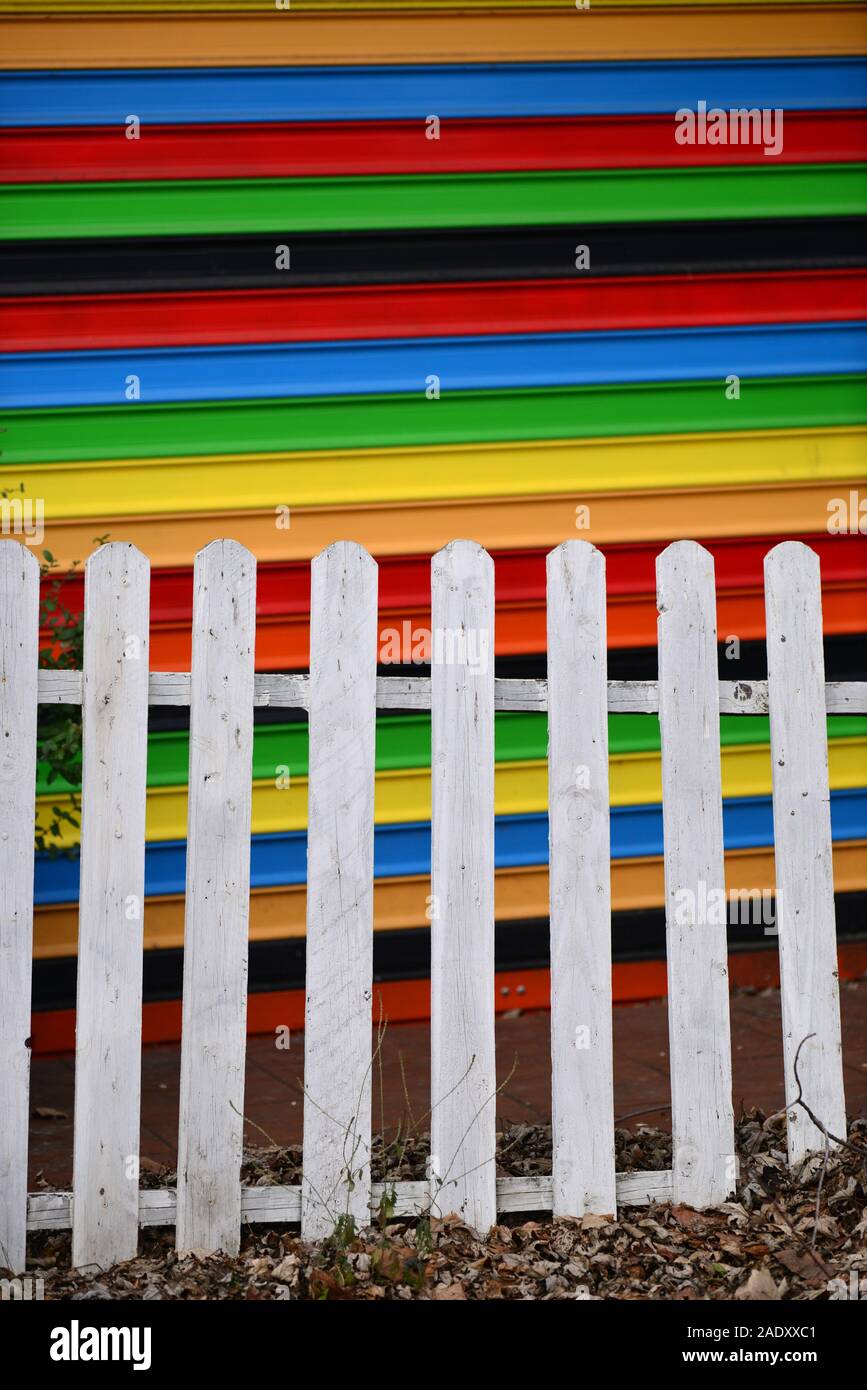 White picket fence against colorful wall Stock Photo - Alamy