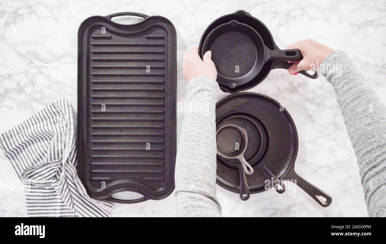 Flat lay. Variety of cast iron kitchenware on a marble countertop Stock ...