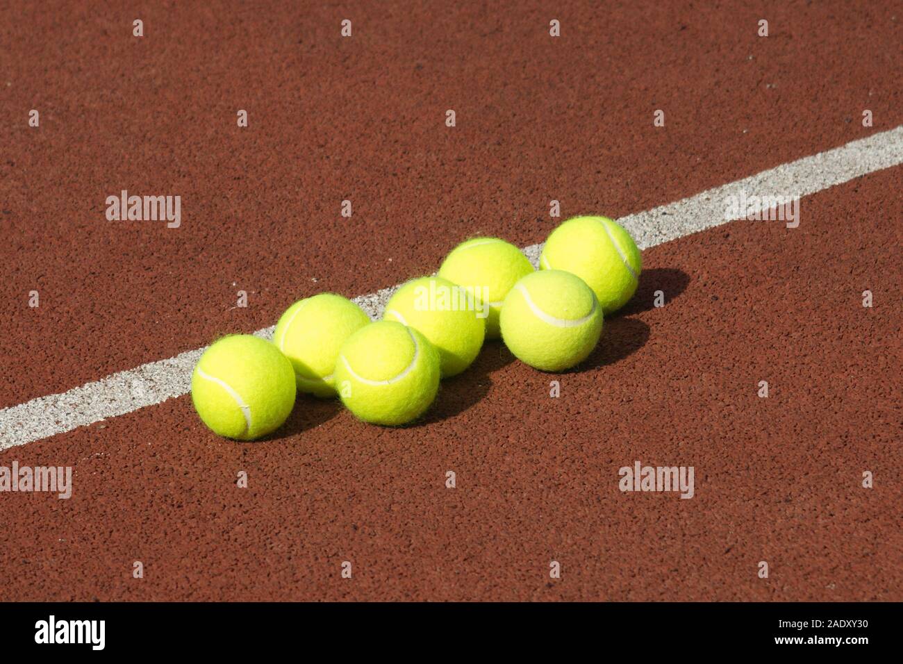 Seven yellow tennis balls near court marking side view Stock Photo - Alamy