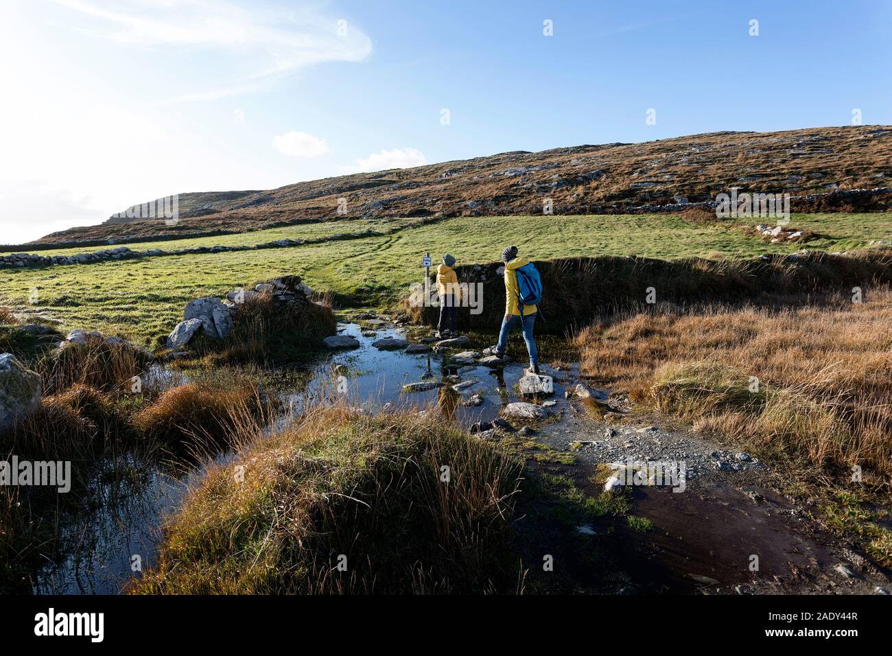 Mother and son hiking to castle ruins, Scenic sight of Dunlough Castle ...
