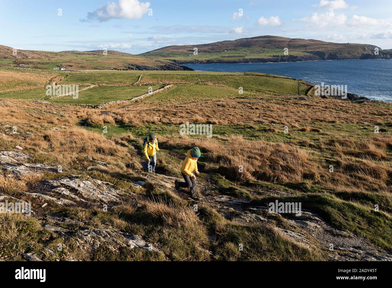 Mother and son hiking to castle ruins, Scenic sight of Dunlough Castle ...