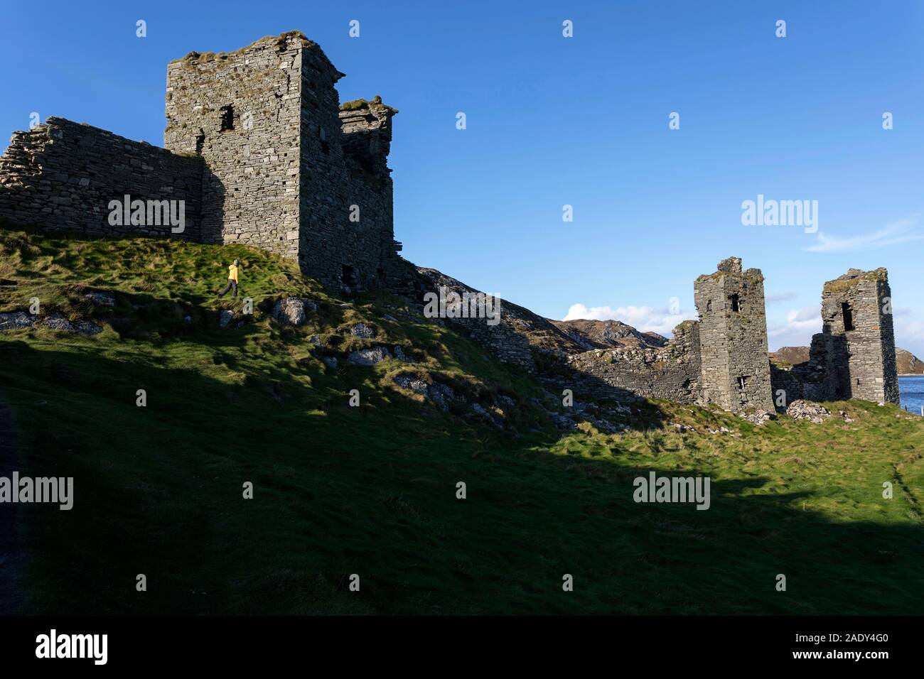 Young boy hiking to castle ruins, Scenic sight of Dunlough Castle ...