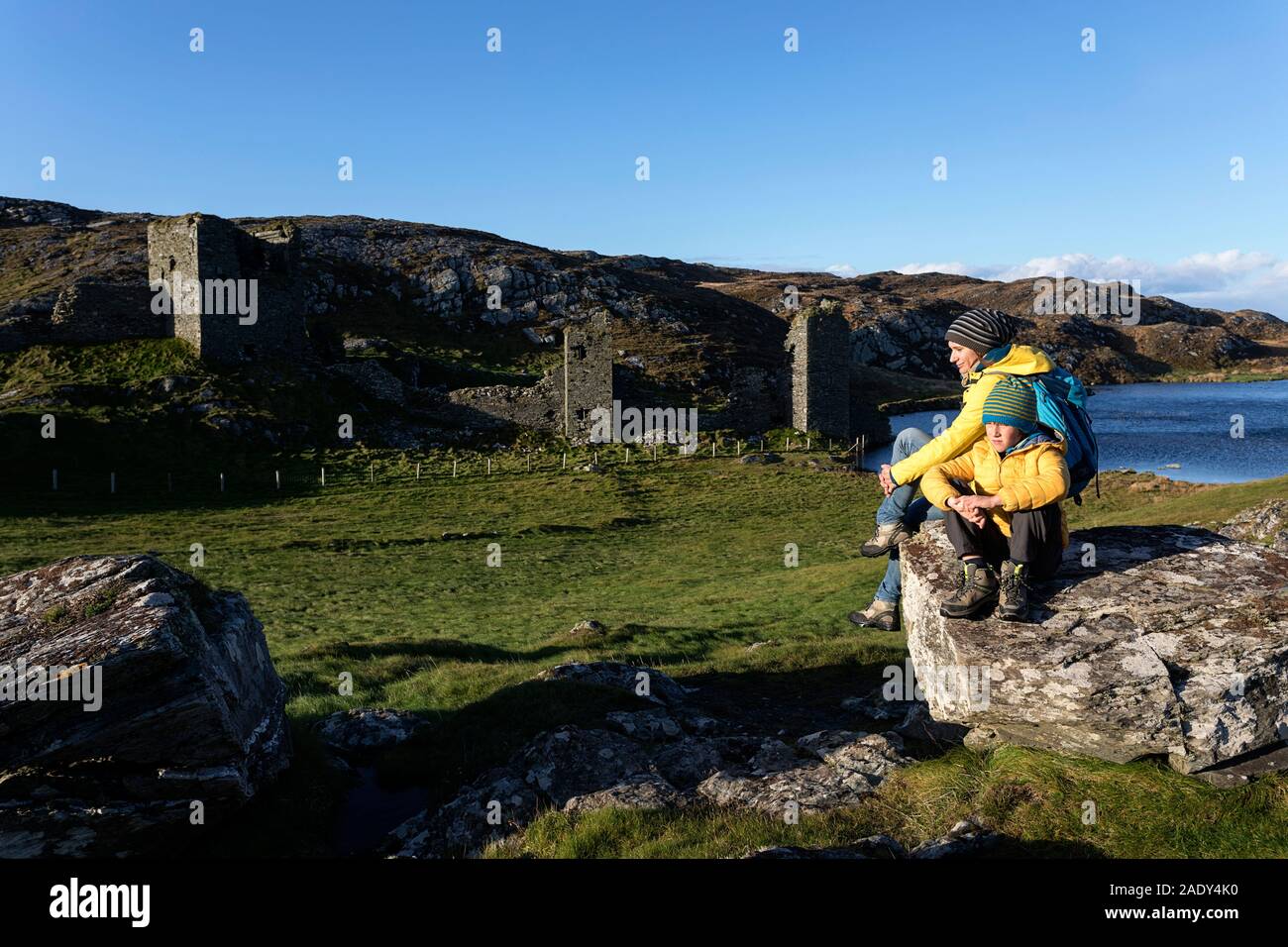 Mother and son hiking to castle ruins, Scenic sight of Dunlough Castle ...