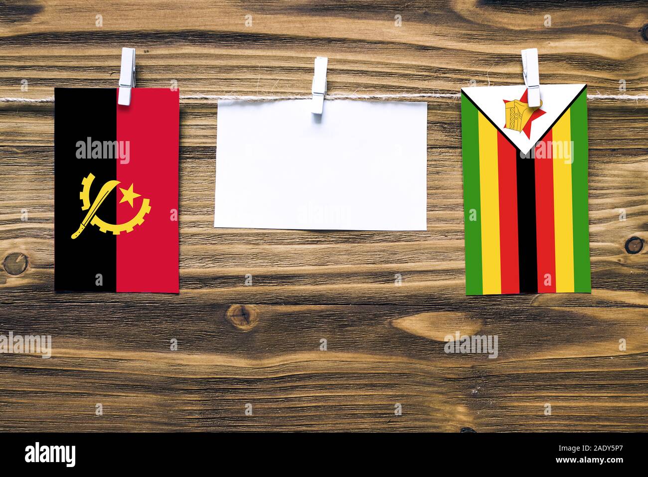 Hanging flags of Angola and Zimbabwe attached to rope with clothes pins ...