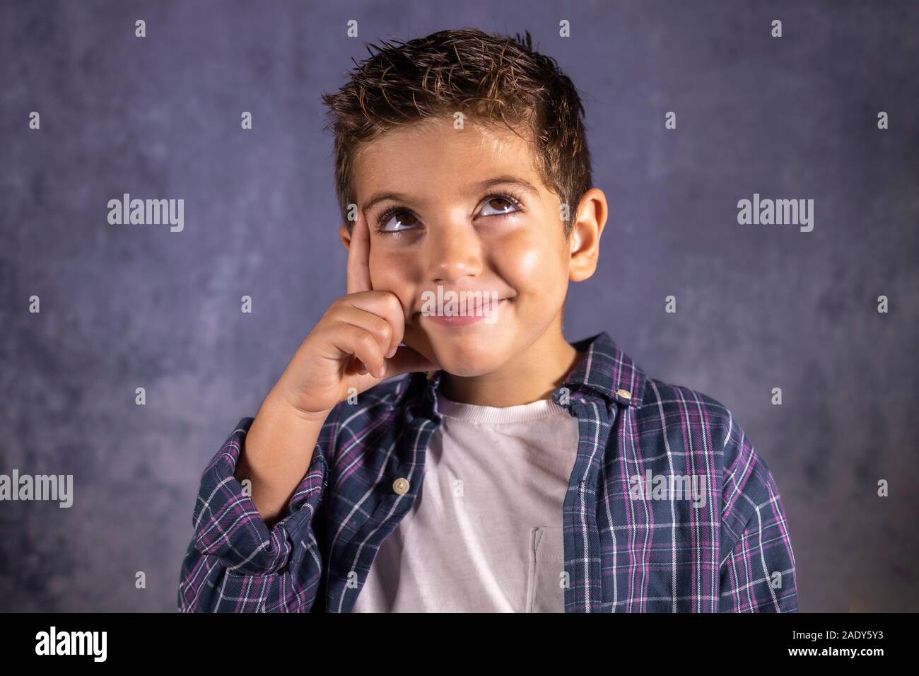 Little boy using his imagination isolated in blue Stock Photo - Alamy