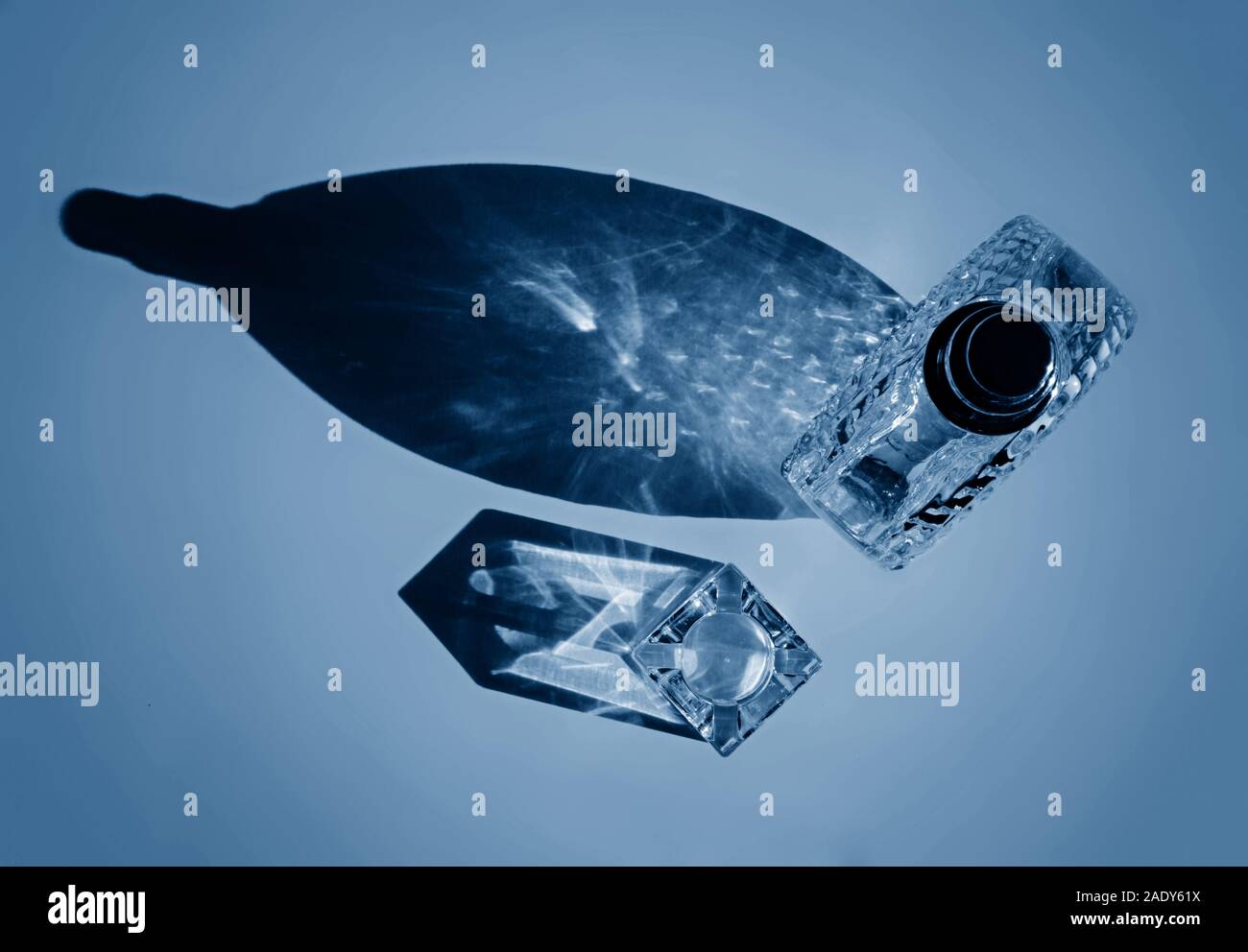 Bottle of perfume with contrast of light and shadows in blue tones ...