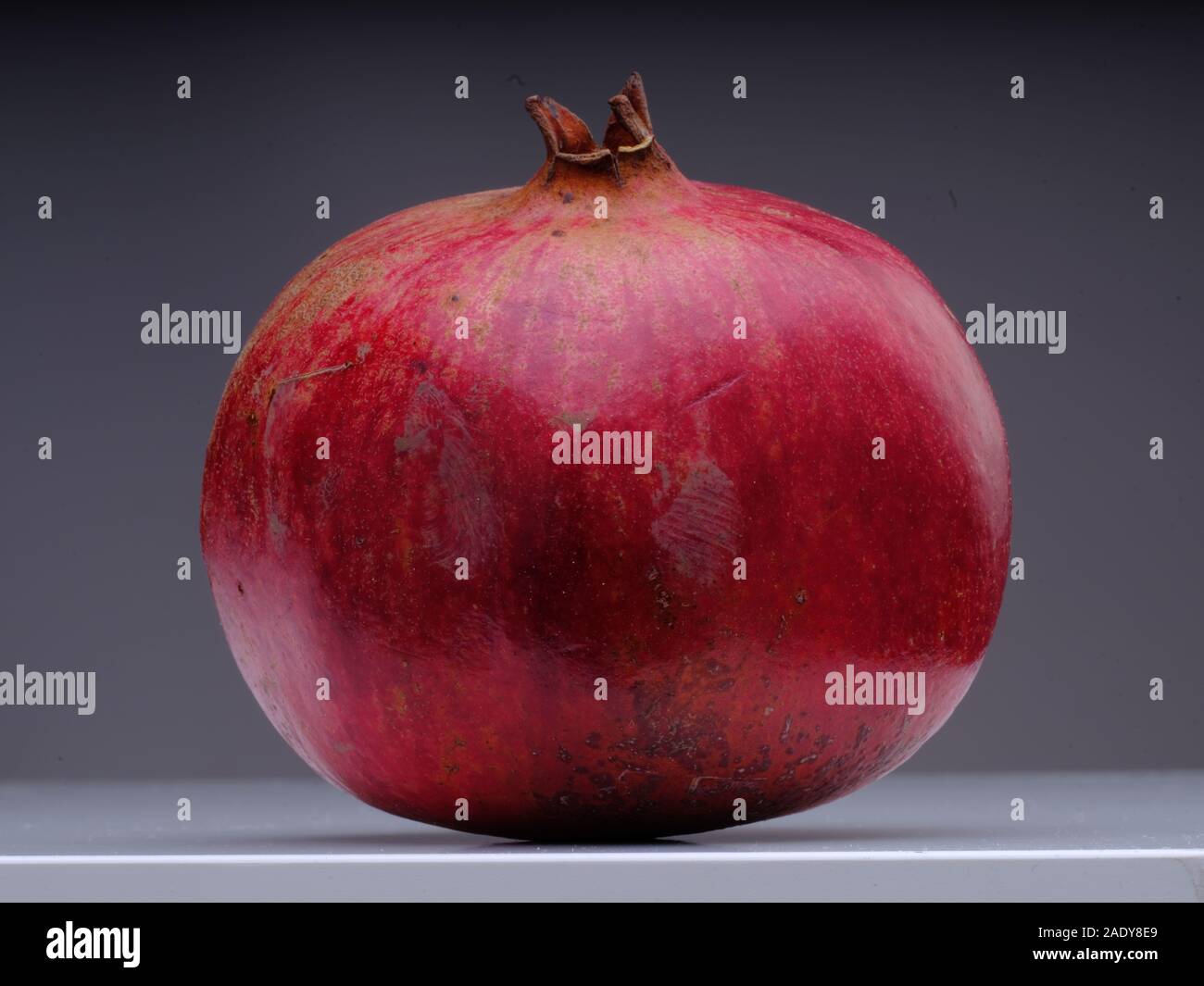 Close up high resolution organic pomegranate on a grey background Stock ...