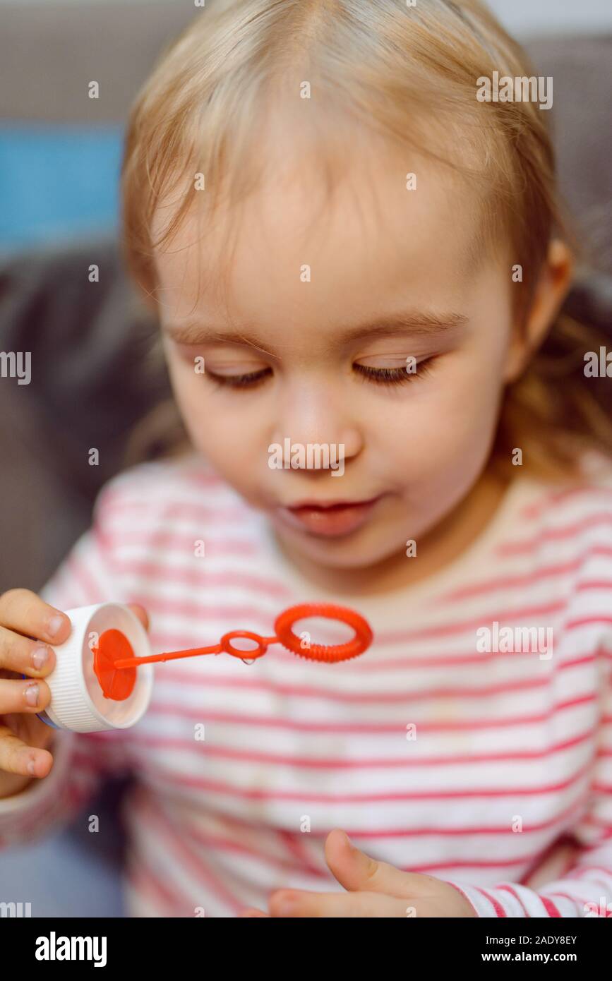 little girl doing bubbles in the livingroom. One year old Stock Photo ...