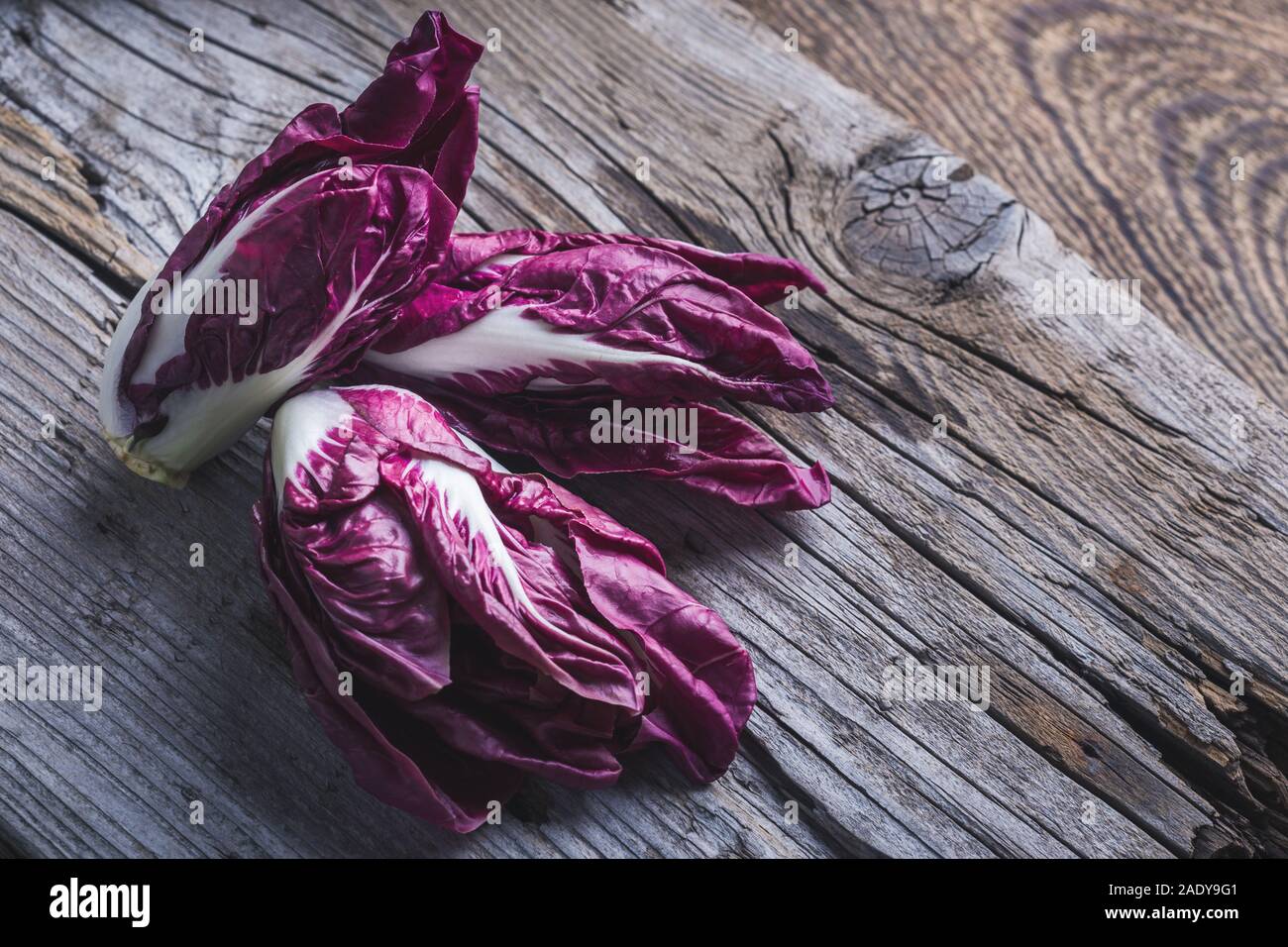 Fresh baby radicchio on wooden board. Healthy vegan plant based food on ...