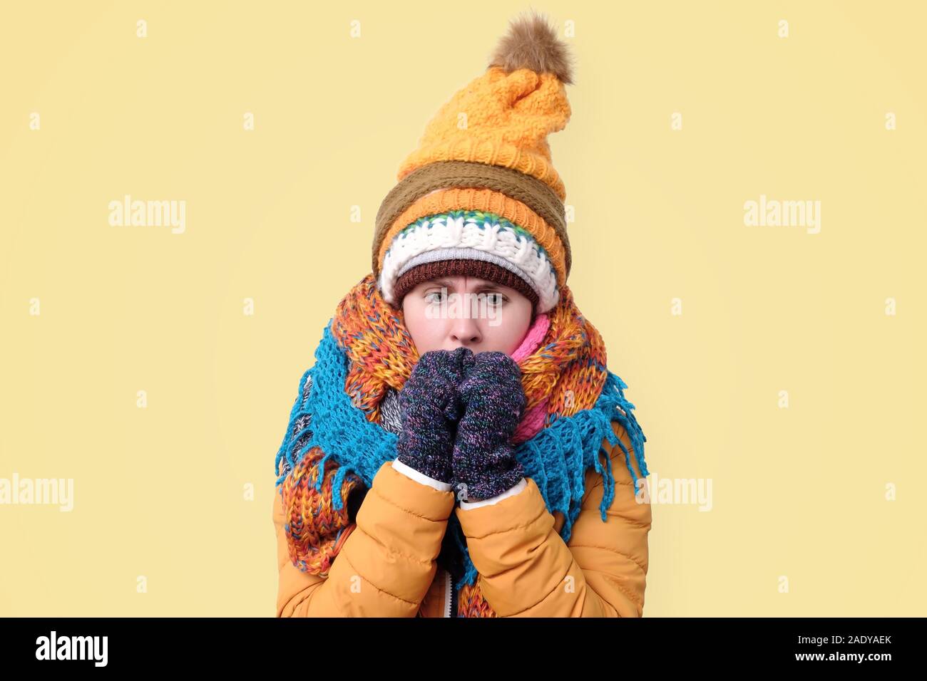 Frozen Girl in hat and scar shivering because of winter weather. Studio ...