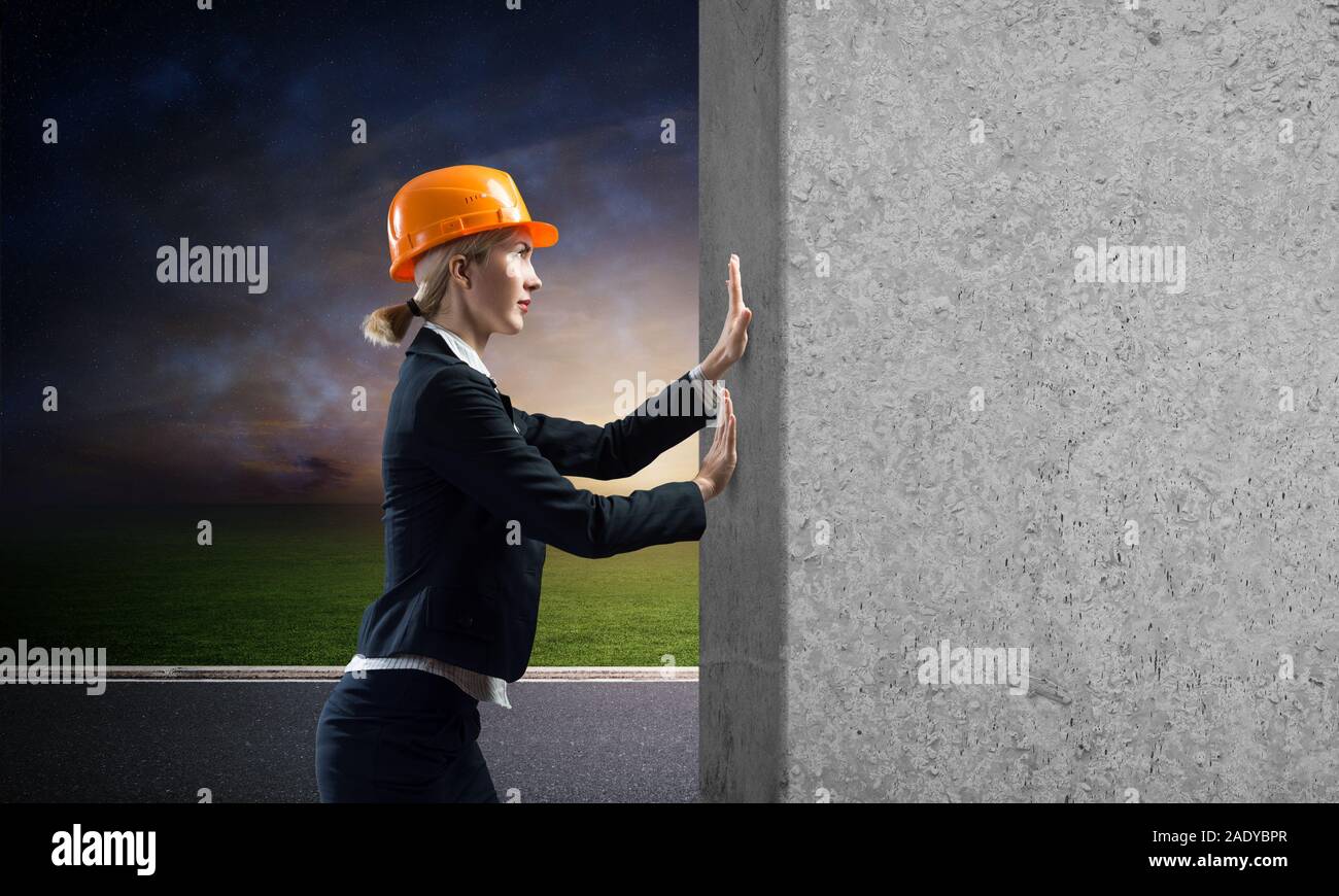 Beautiful woman architect pushing concrete wall Stock Photo - Alamy