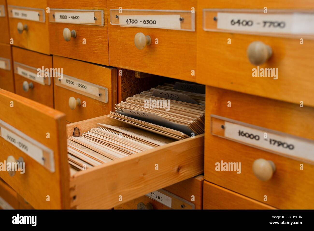 Files catalog with open drawer. Vintage wood cabinet in the library ...