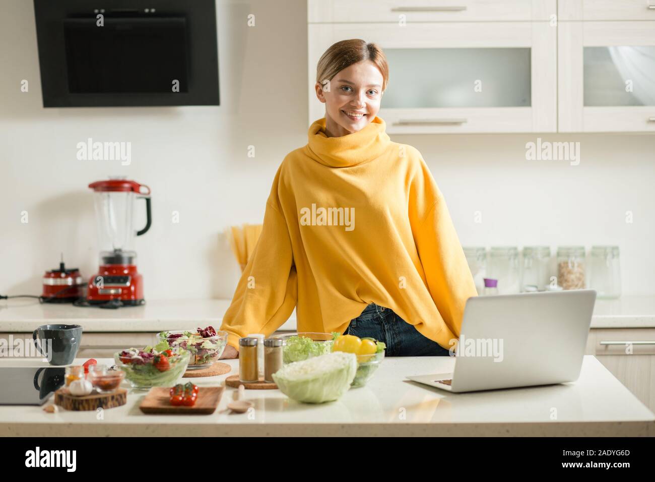 Cheerful lady cooking in the kitchen and smiling Stock Photo - Alamy