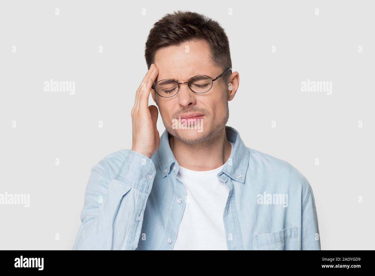 Close up head shot of young man having headache migraine Stock Photo ...