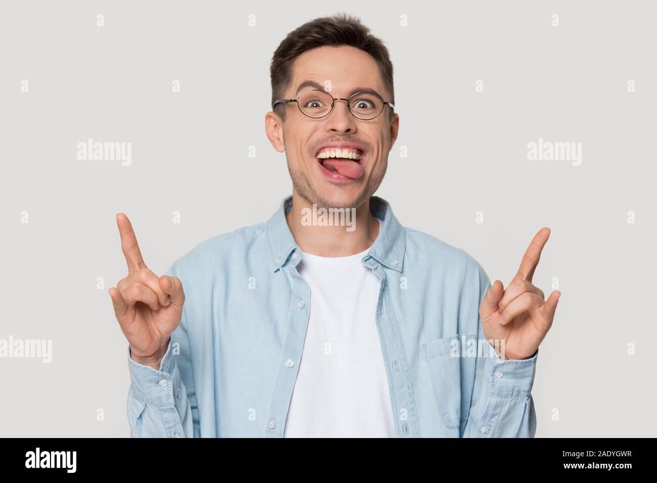 Funny crazy man showing rock-n-roll gesture with sticked out tongue ...
