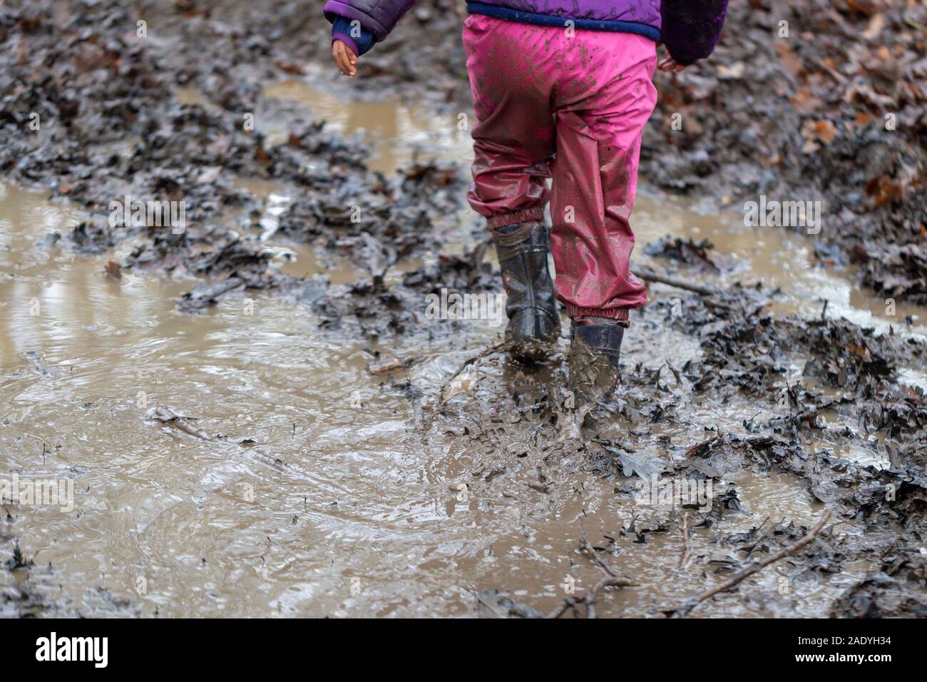 Young children playing in a muddy puddle Stock Photo - Alamy