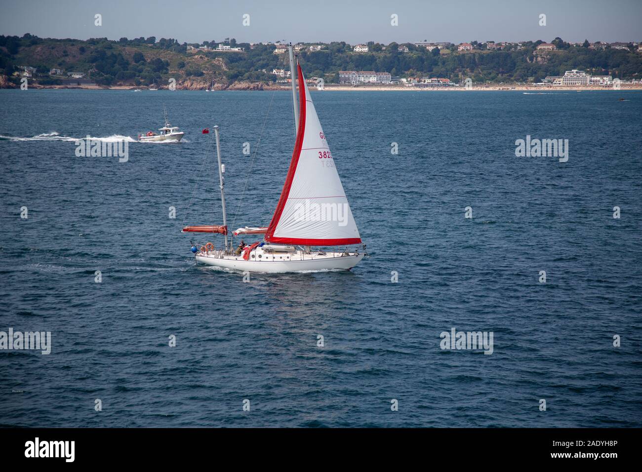 Sailing boat, foresail coming into harbour, Channel Islands Stock Photo ...