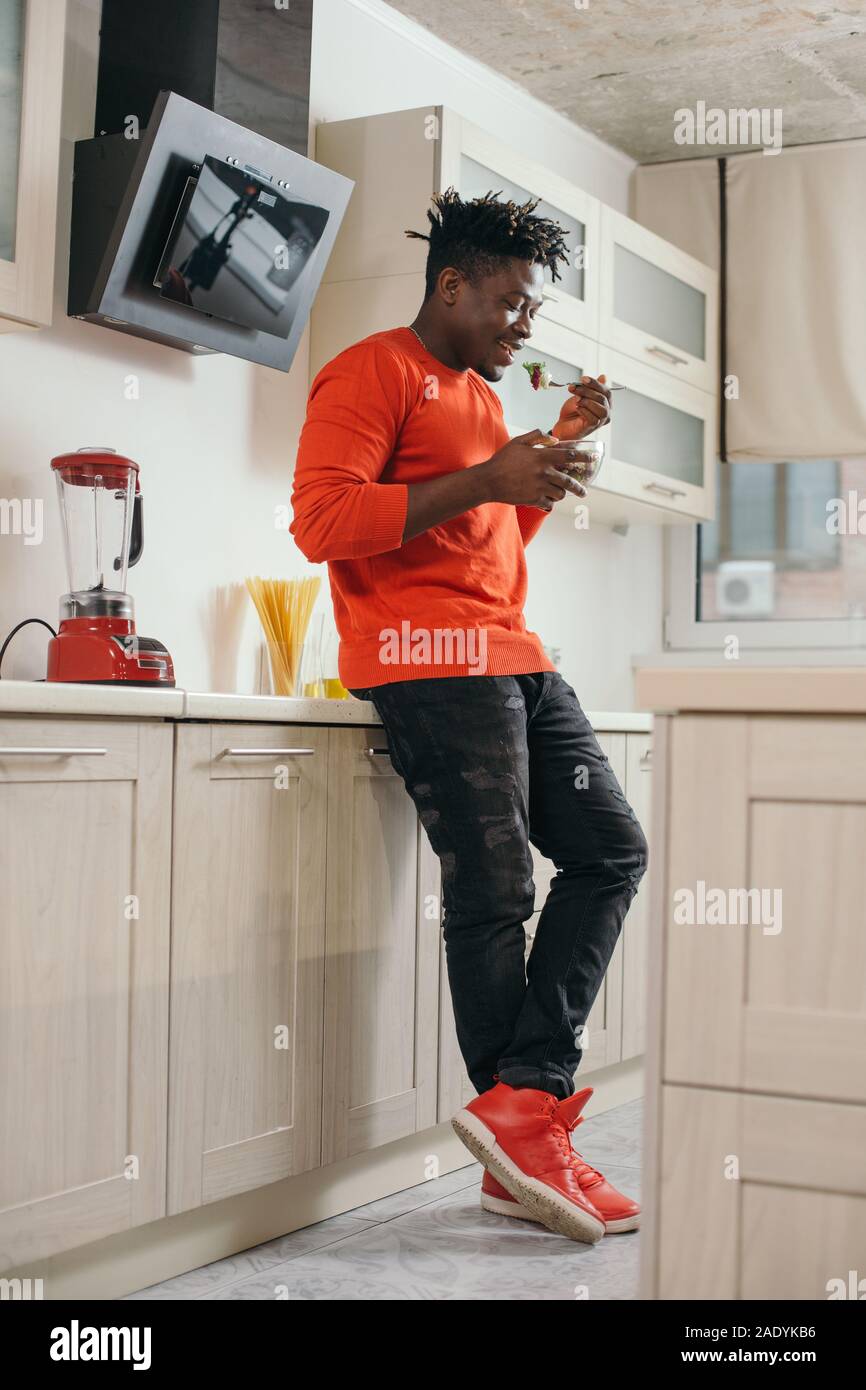 Full length of the man eating salad in his kitchen Stock Photo - Alamy