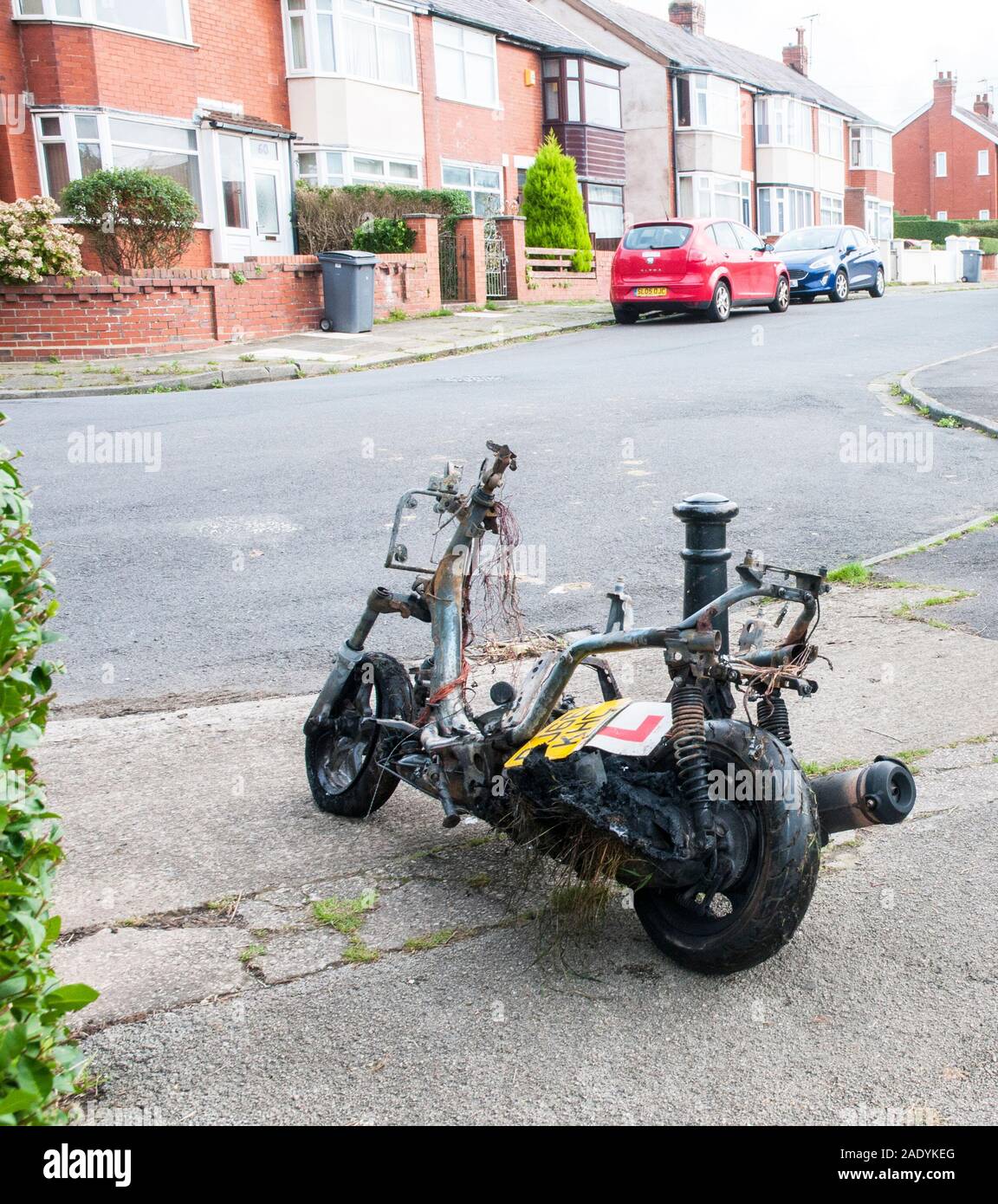 Burnt out motor scooter waiting to be collected for scrap after being ...