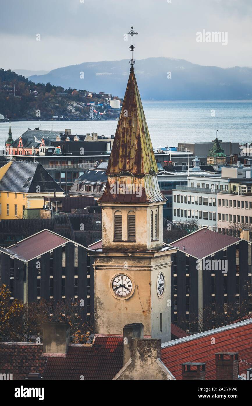 Old and high clock tower above city houses and roof tops in industrial ...