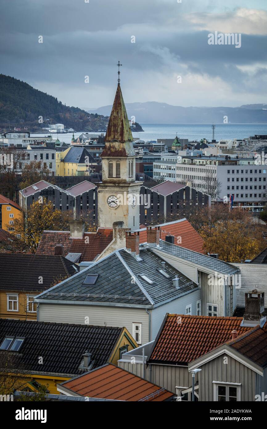 Old and high clock tower above city houses and roof tops in industrial ...