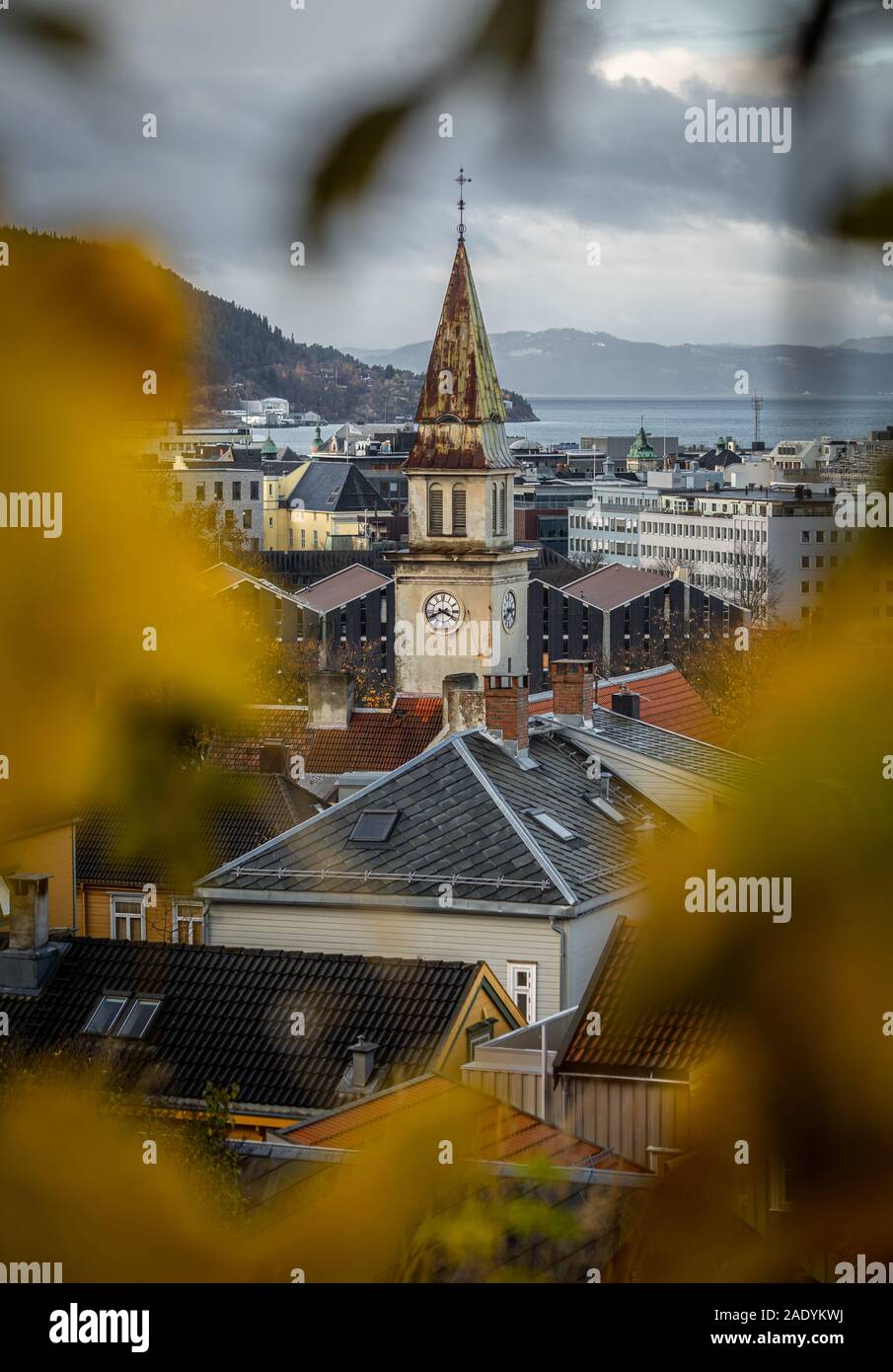 Old and high clock tower above city houses and roof tops in industrial ...