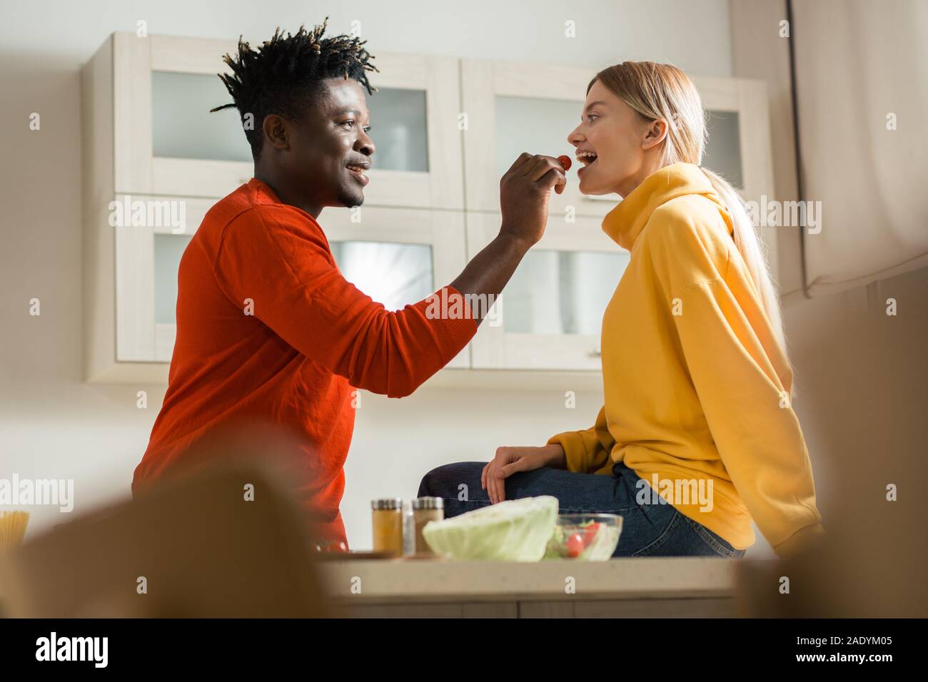 Kind young man feeding his smiling girlfriend with cherry tomato Stock ...