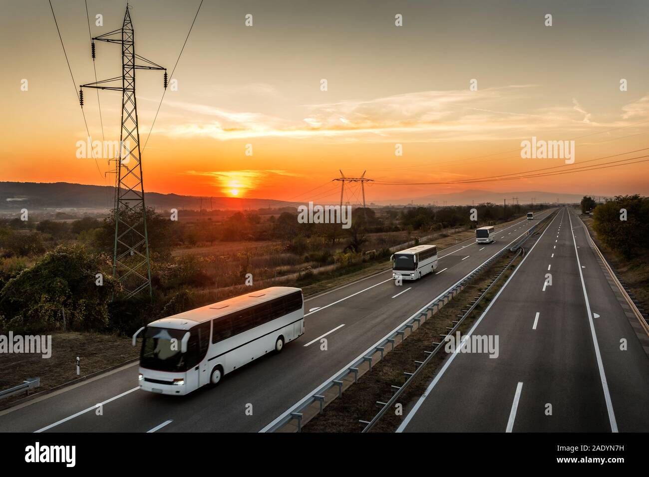 Caravan or convoy of Four buses in line traveling on a country highway ...