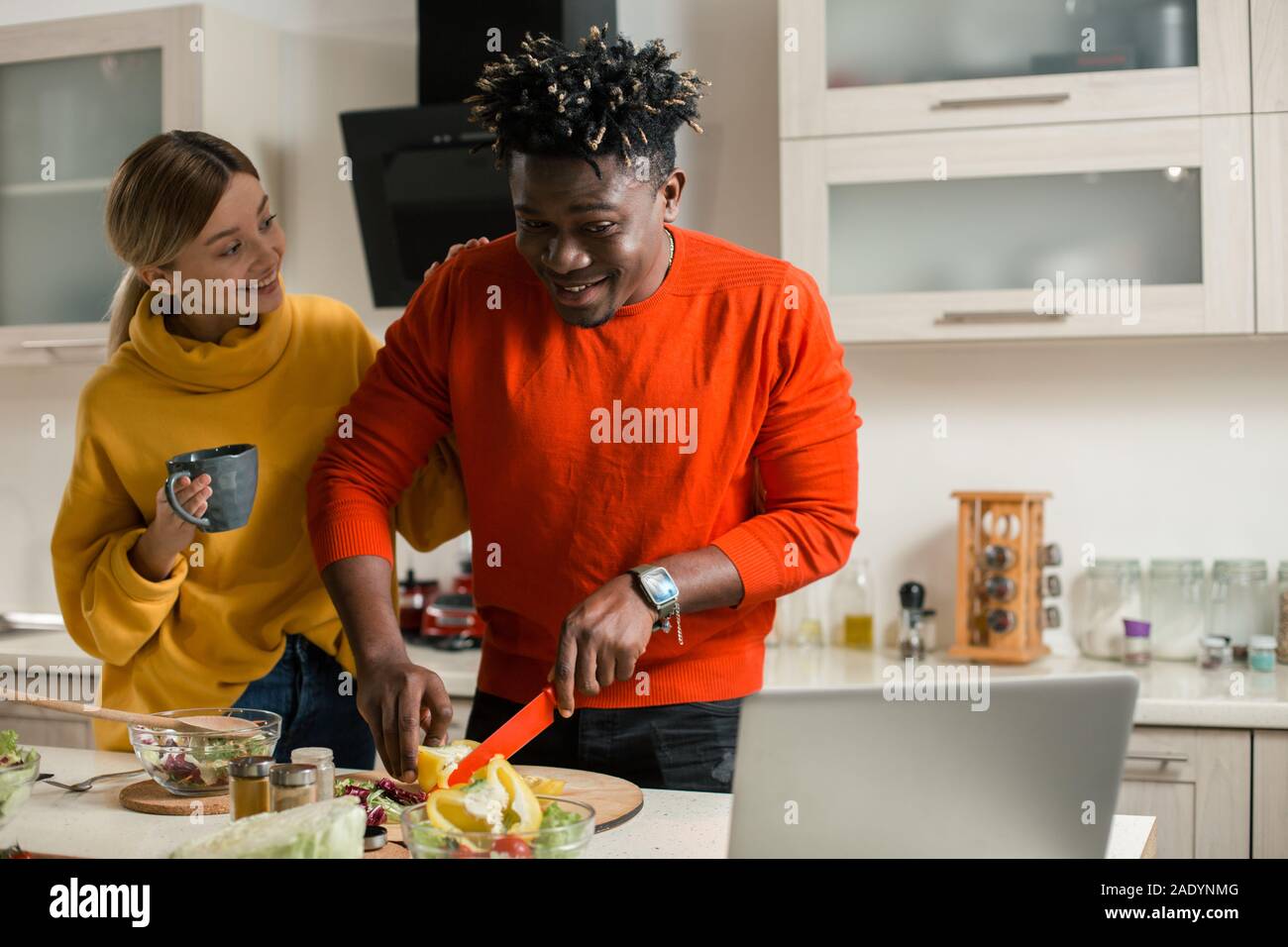 Happy man cooking and girlfriend encouraging him Stock Photo - Alamy