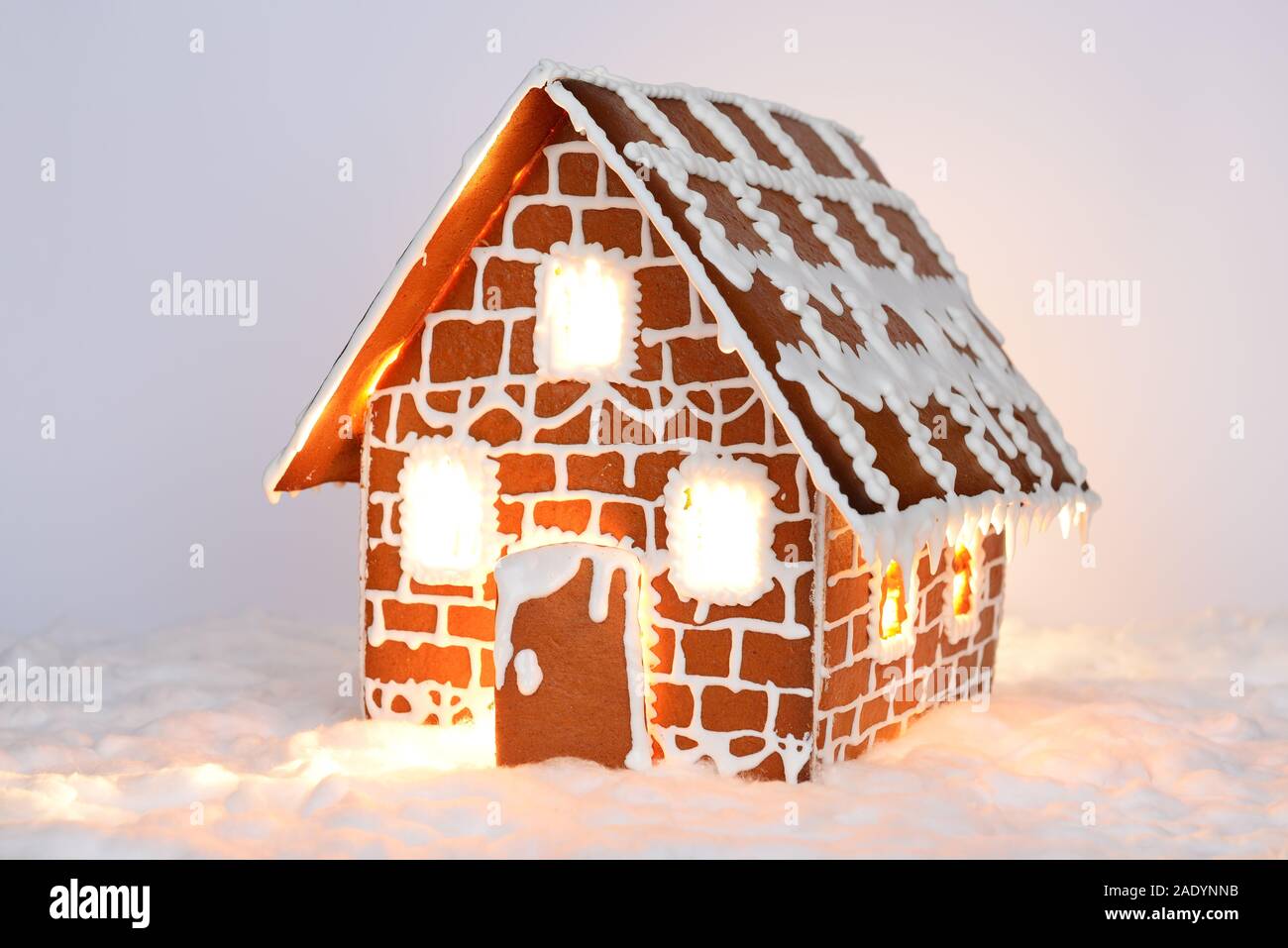 The hand-made eatable gingerbread house with light inside and snow ...