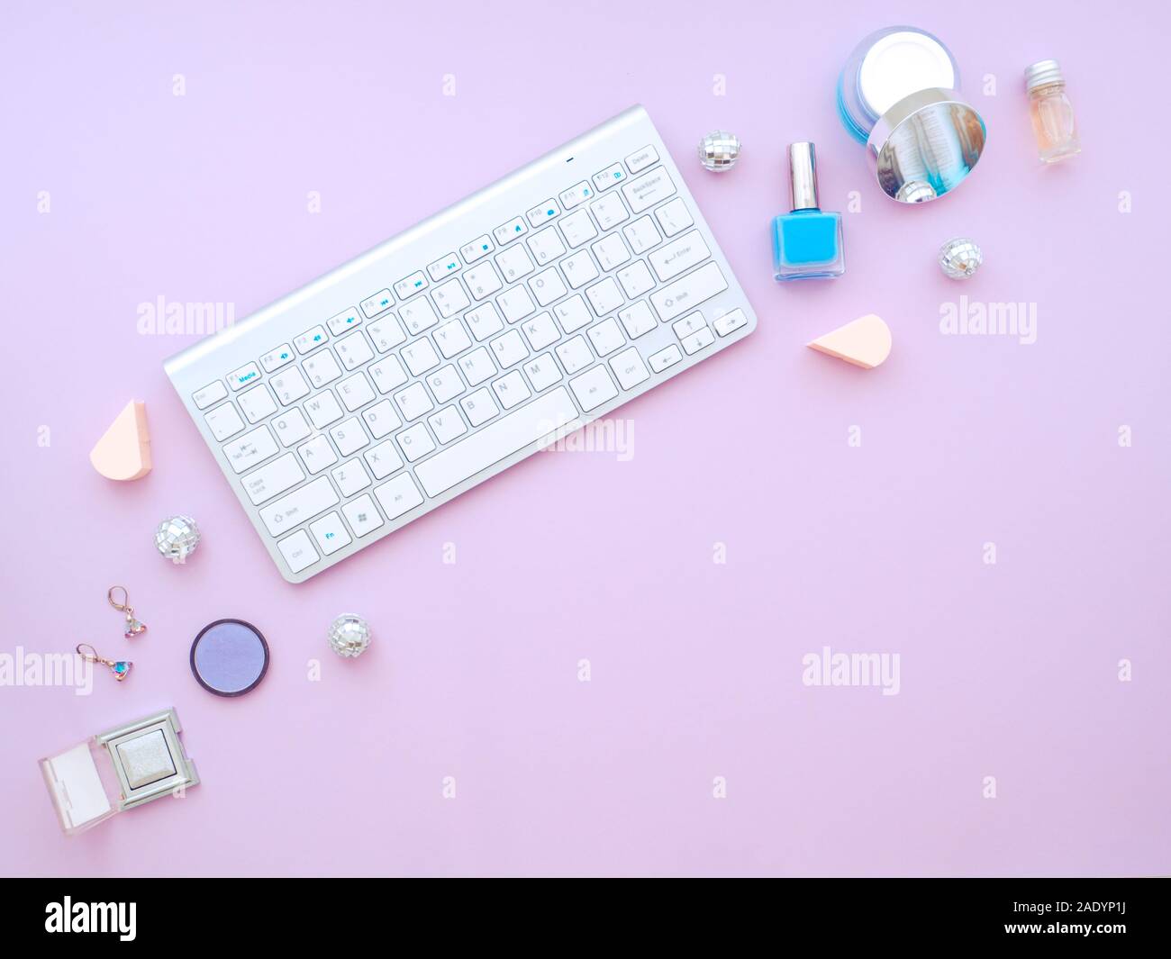 Keyboard and makeup tools and cosmetic products around it isolated on a ...