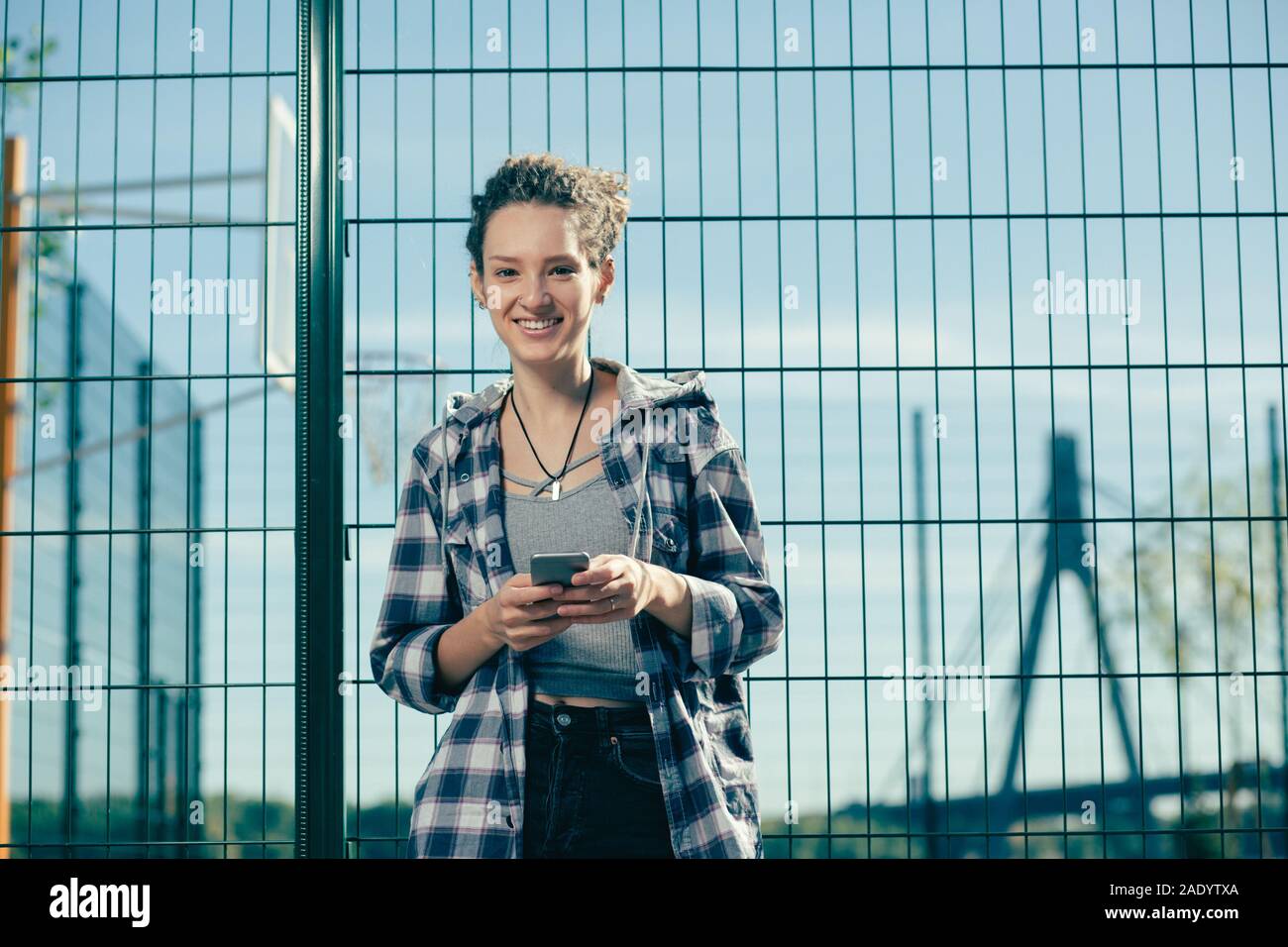 Emotional lady feeling happy while standing with her smartphone ...