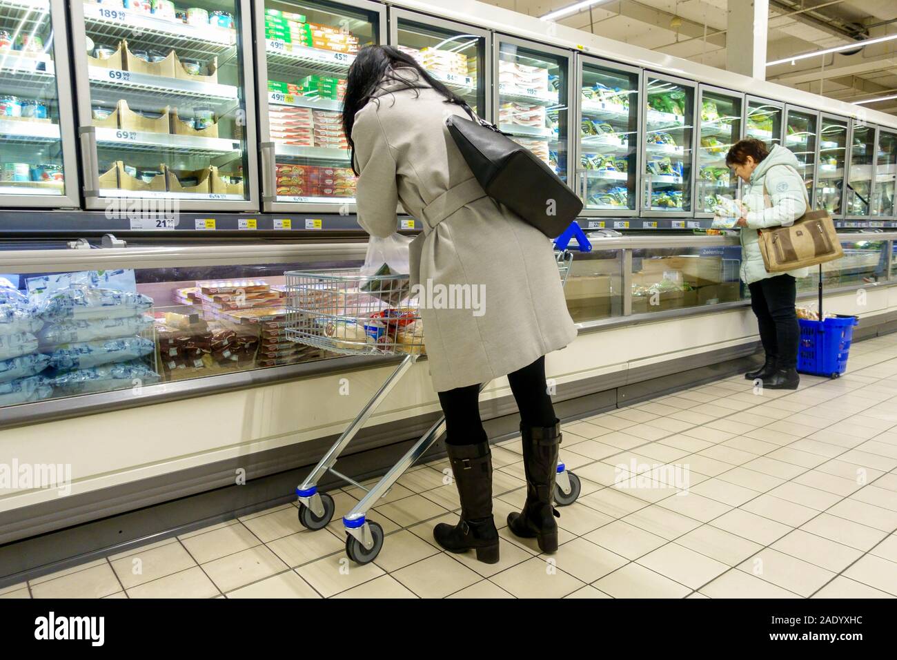 Two women shopping choose frozen products in supermarket shelves, Tesco ...