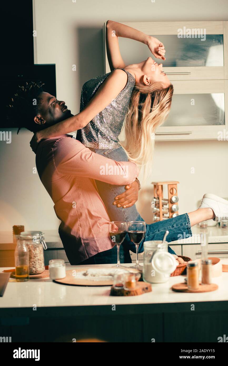 Happy lady throwing her head back while being in arms of boyfriend Stock Photo - Alamy