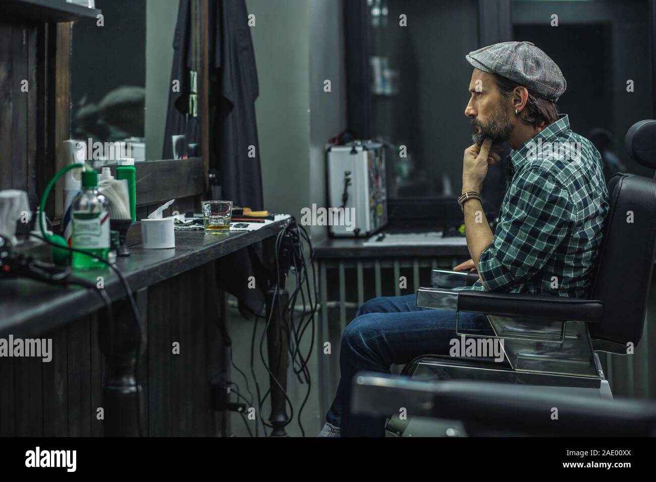 Waist up of serious man looking at his reflection and thinking Stock ...