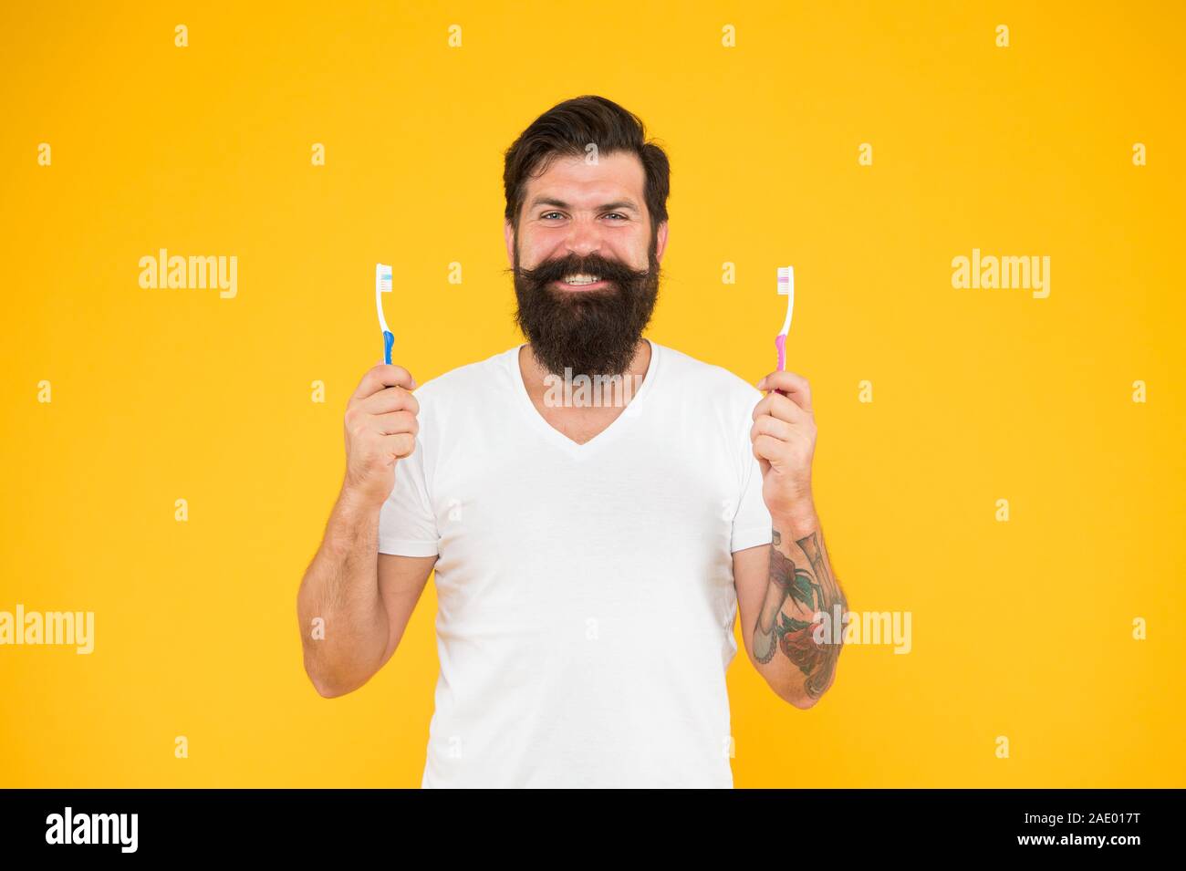 Wanted happy teeth. Happy hipster hold brushes yellow background ...