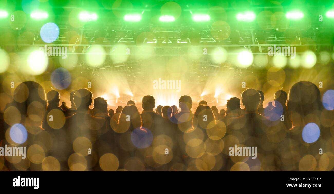 Photo of a concert hall with people silhouettes clapping in front of a ...