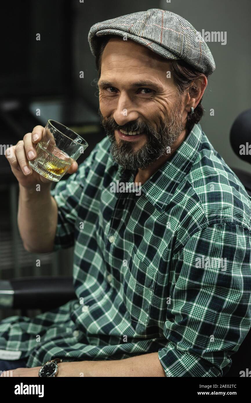 Positive man in checkered shirt smiling and drinking whiskey Stock ...