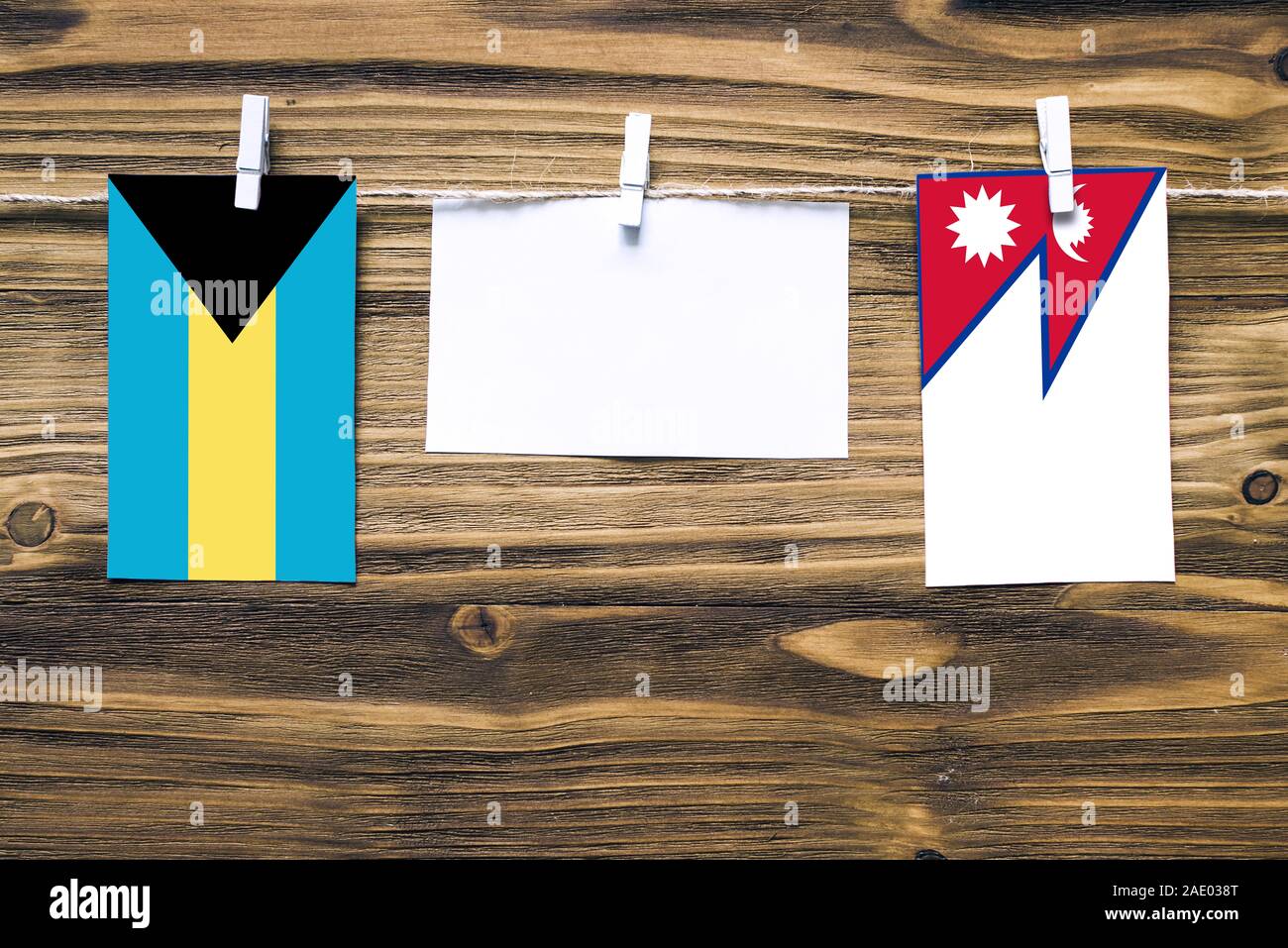 Hanging flags of Bahamas and Nepal attached to rope with clothes pins ...