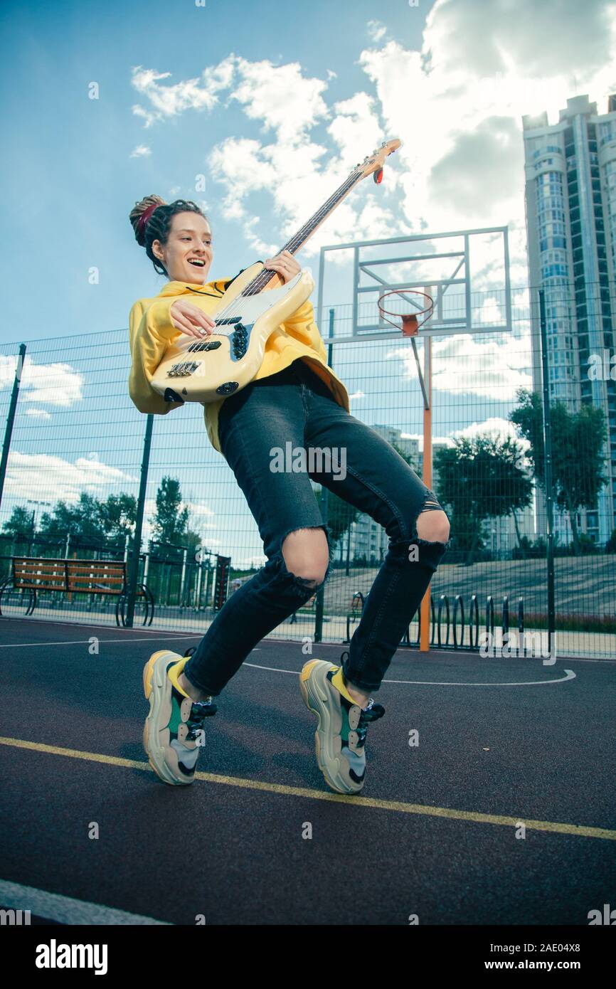 Expressive musician moving while playing the guitar outdoors Stock ...