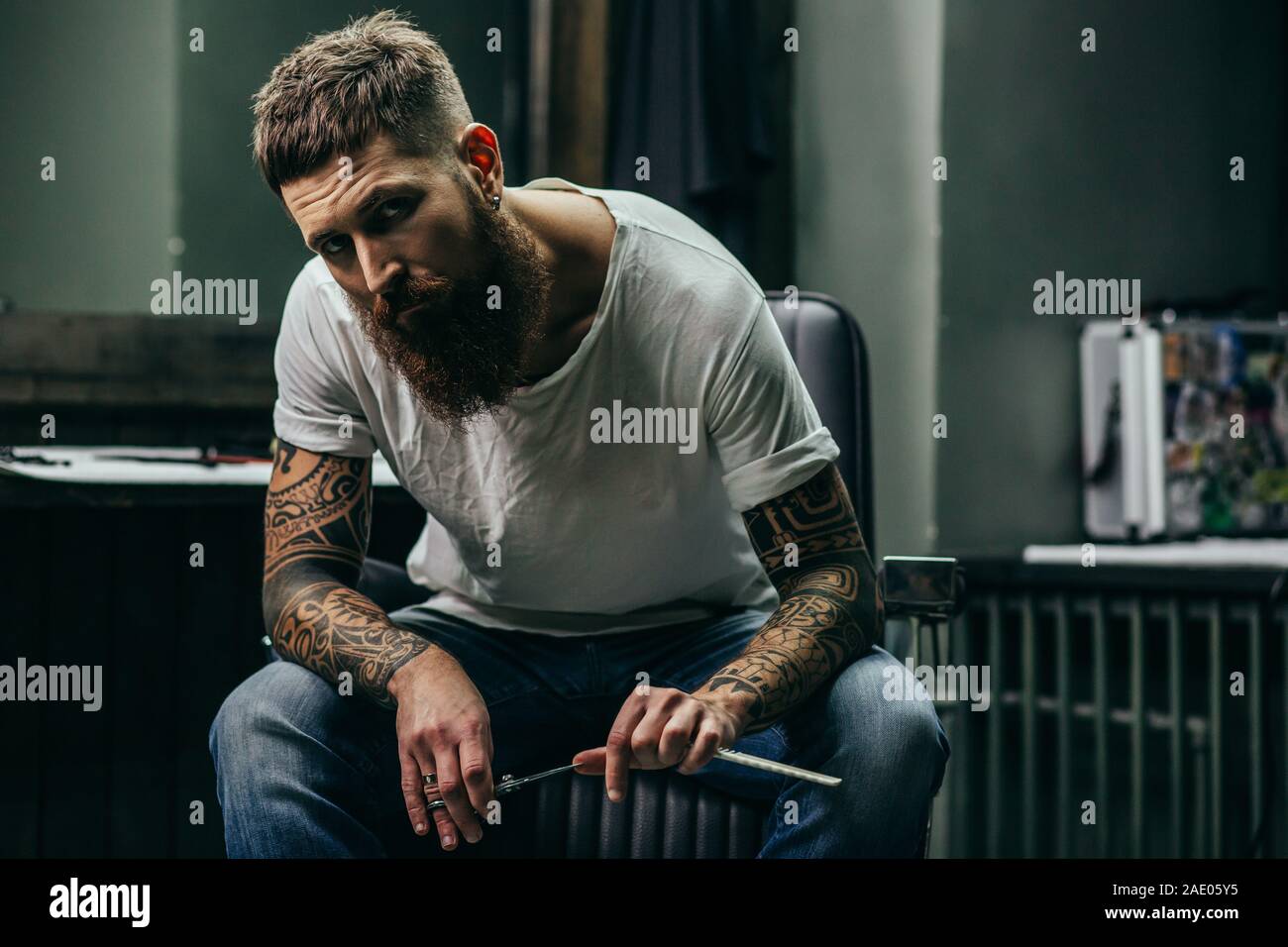 Serious barber frowning while holding straight razor Stock Photo - Alamy