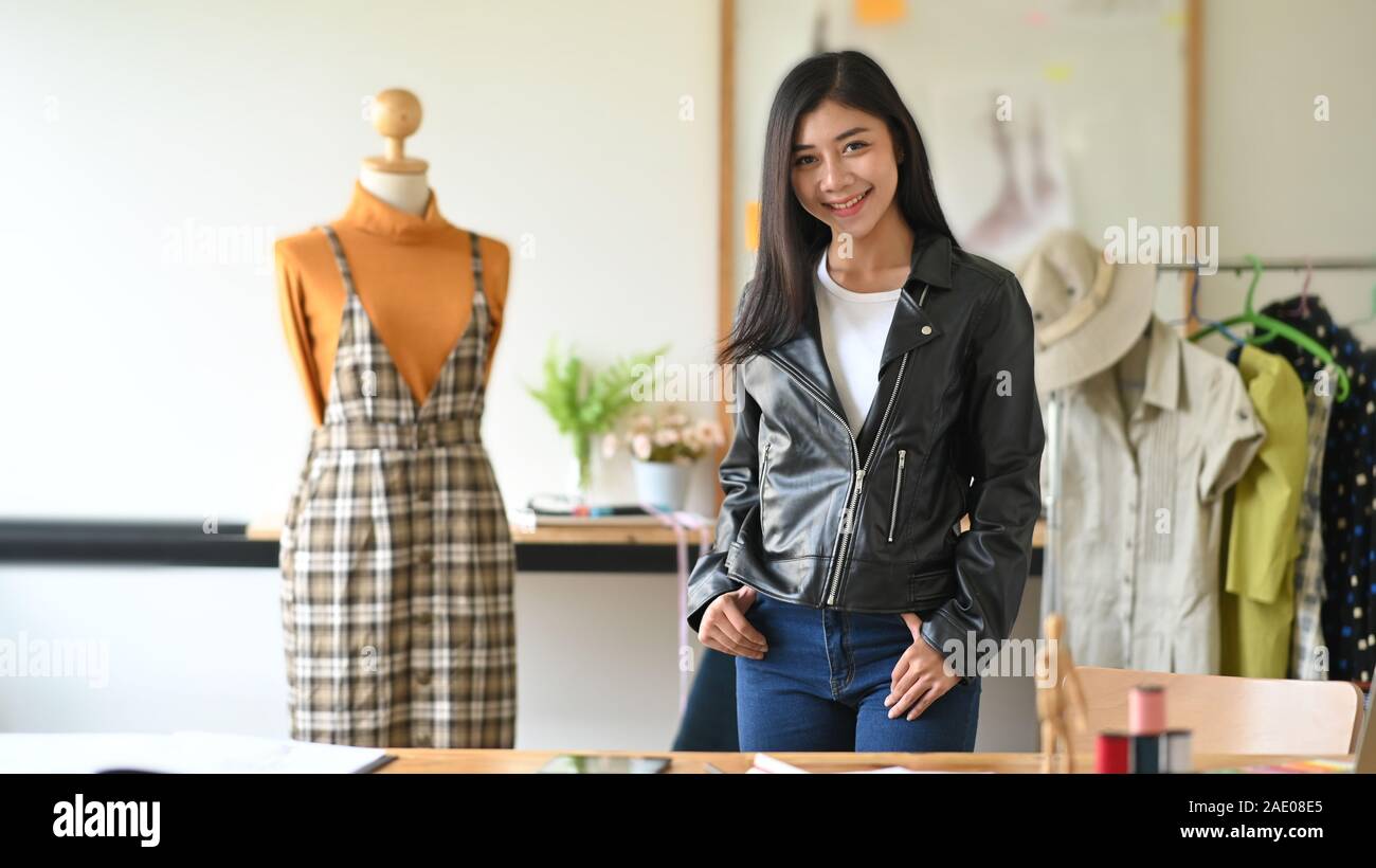 Fashion designer standing near mannequin in studio Stock Photo - Alamy