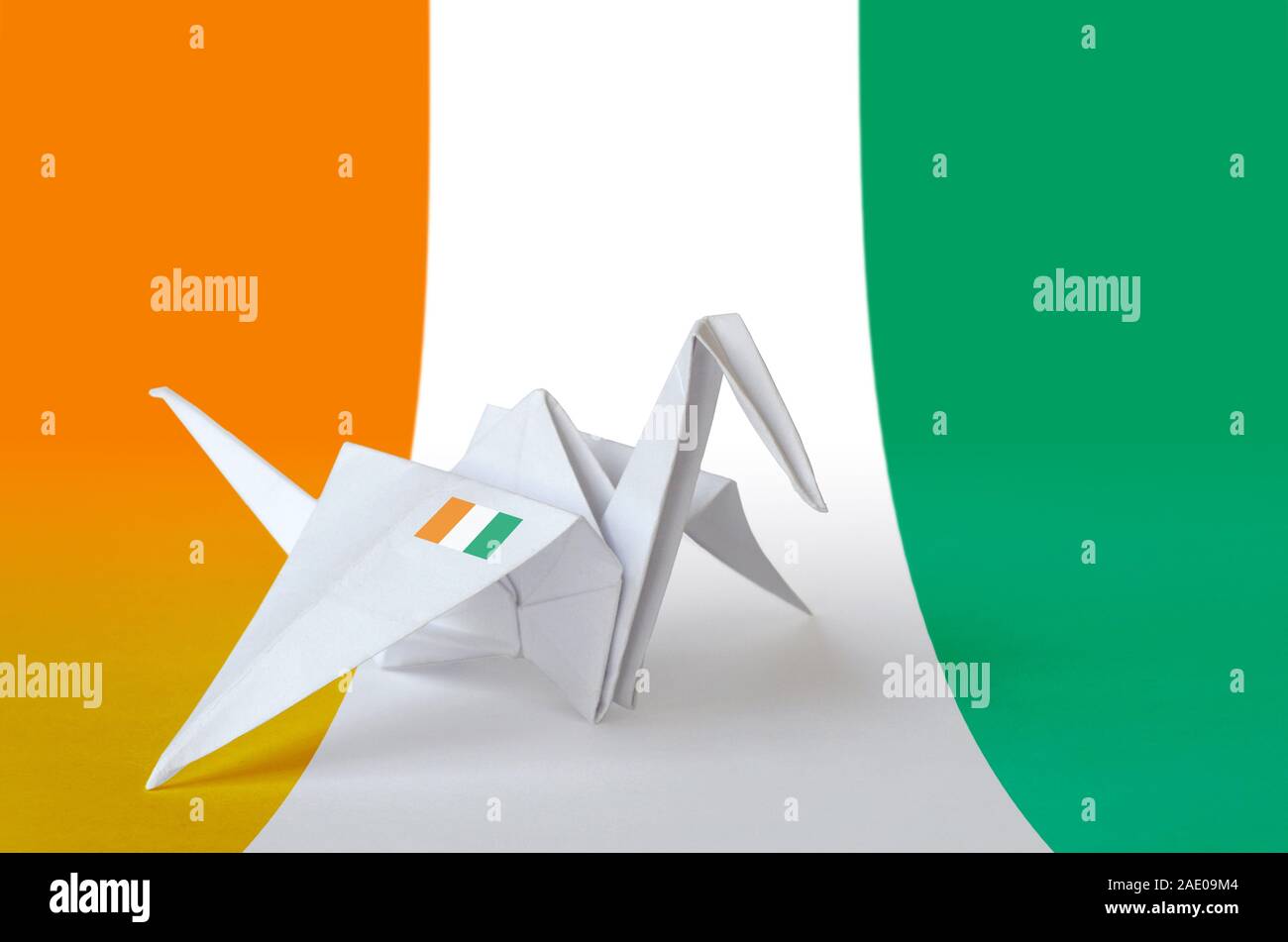 Ivory Coast flag depicted on paper origami crane wing. Oriental ...